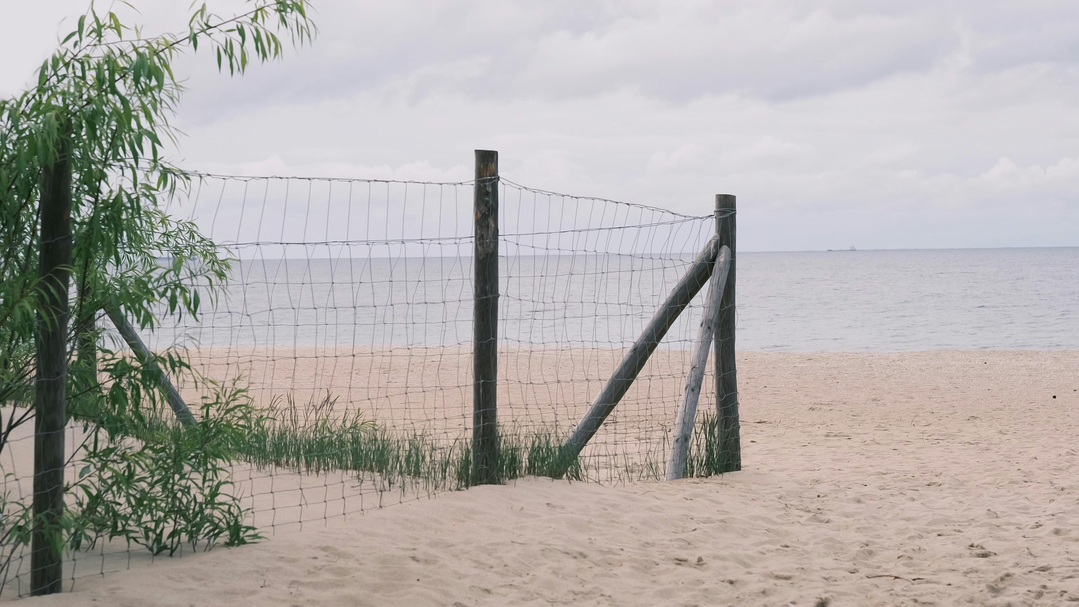 Tranquila Playa De Arena Con Valla De Madera · Foto de stock gratuita