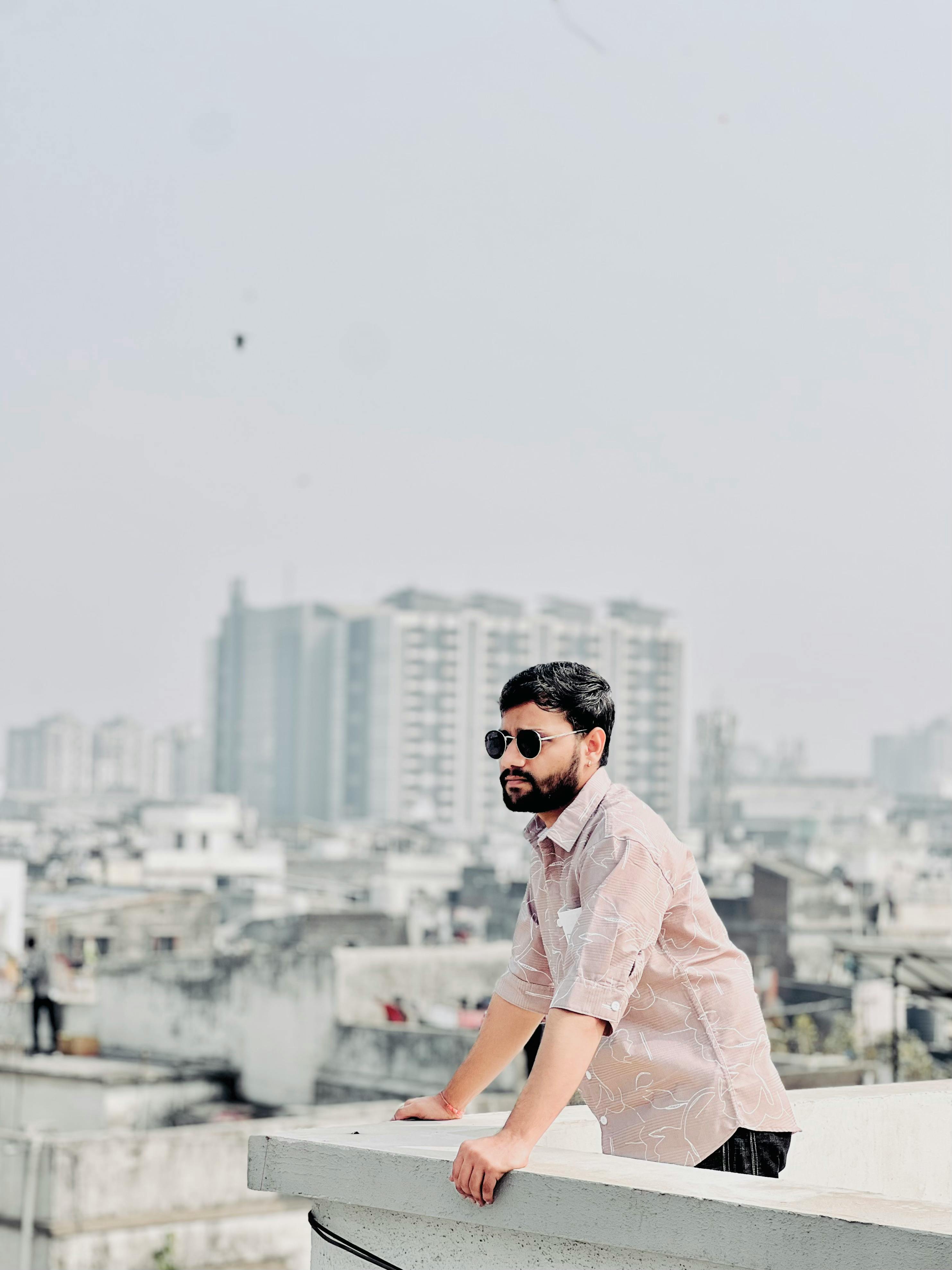 Man on Rooftop with Urban Skyline Background · Free Stock Photo