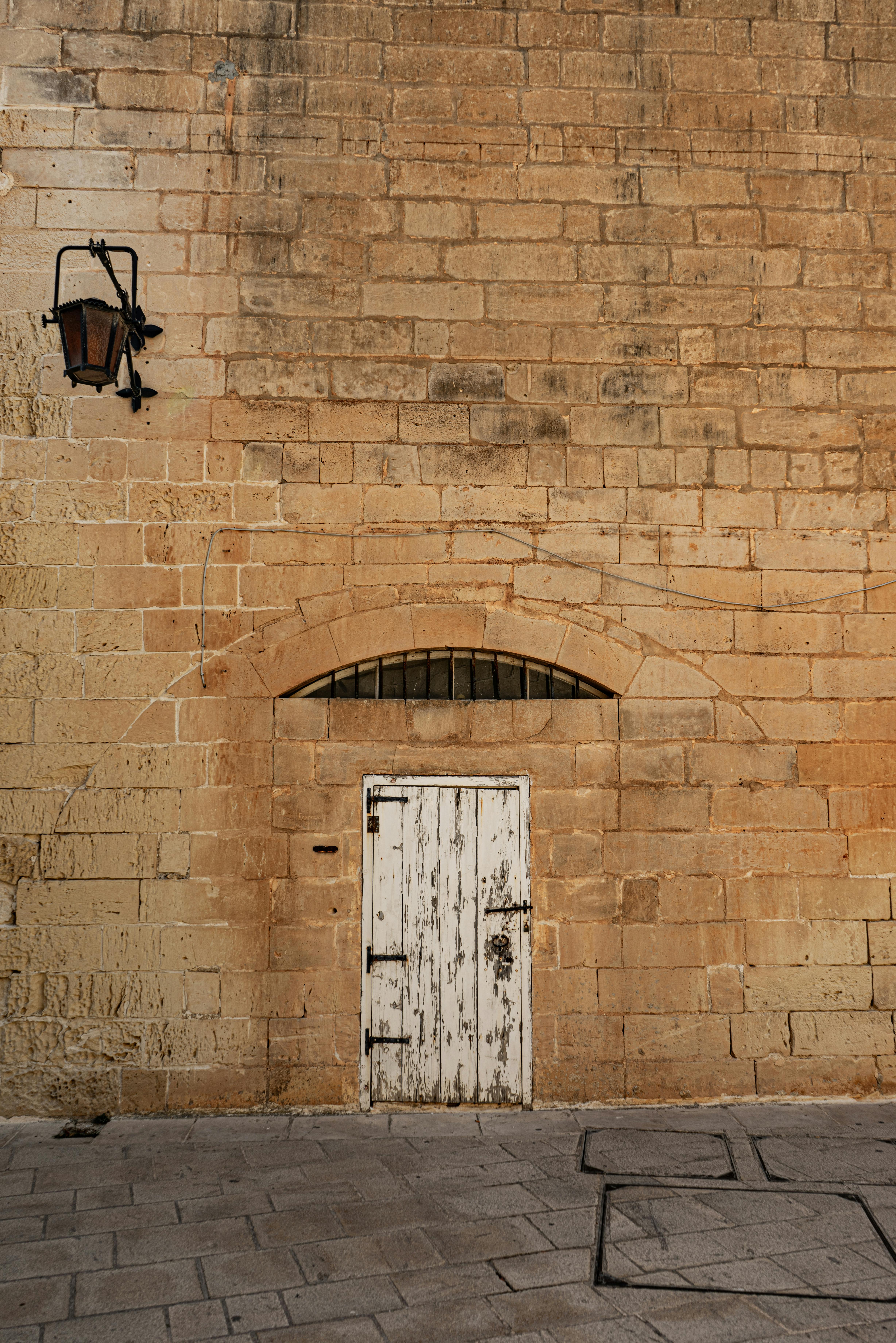 Historic Maltese Stone Wall with Weathered Door · Free Stock Photo