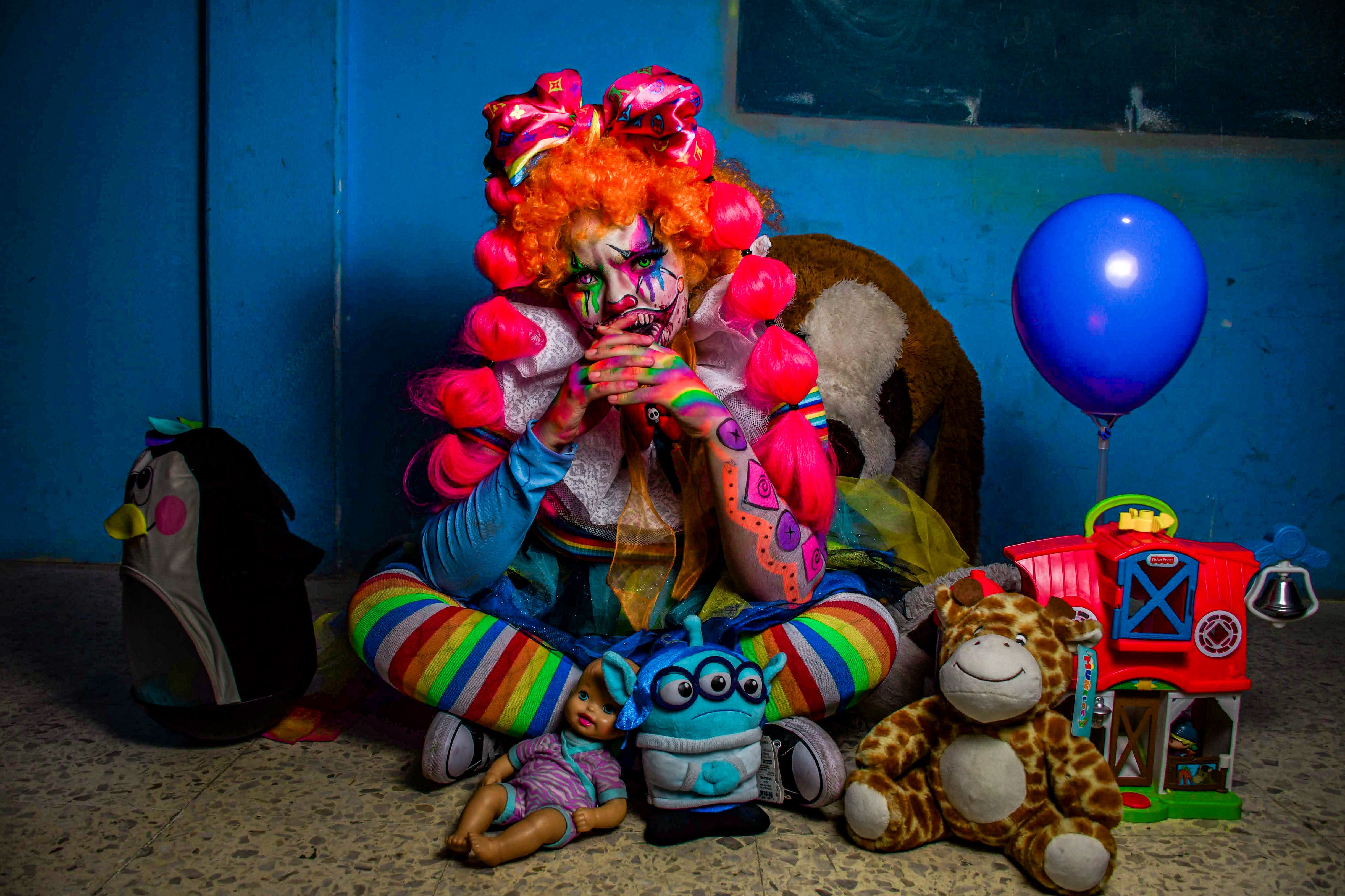 Colorful Clown Surrounded by Toys Indoors · Free Stock Photo
