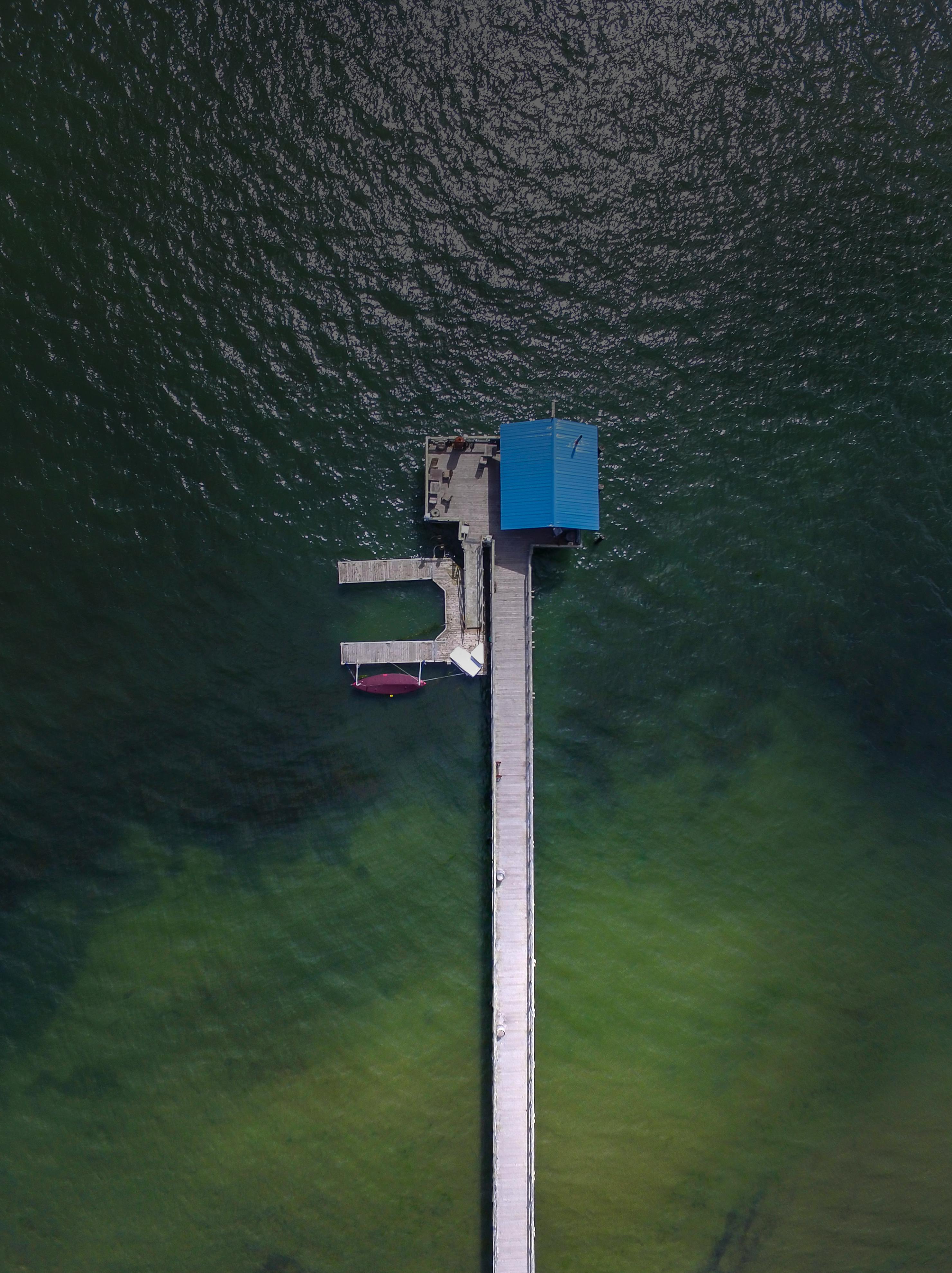 Aerial View of Pier and Boathouse over Green Water · Free Stock Photo