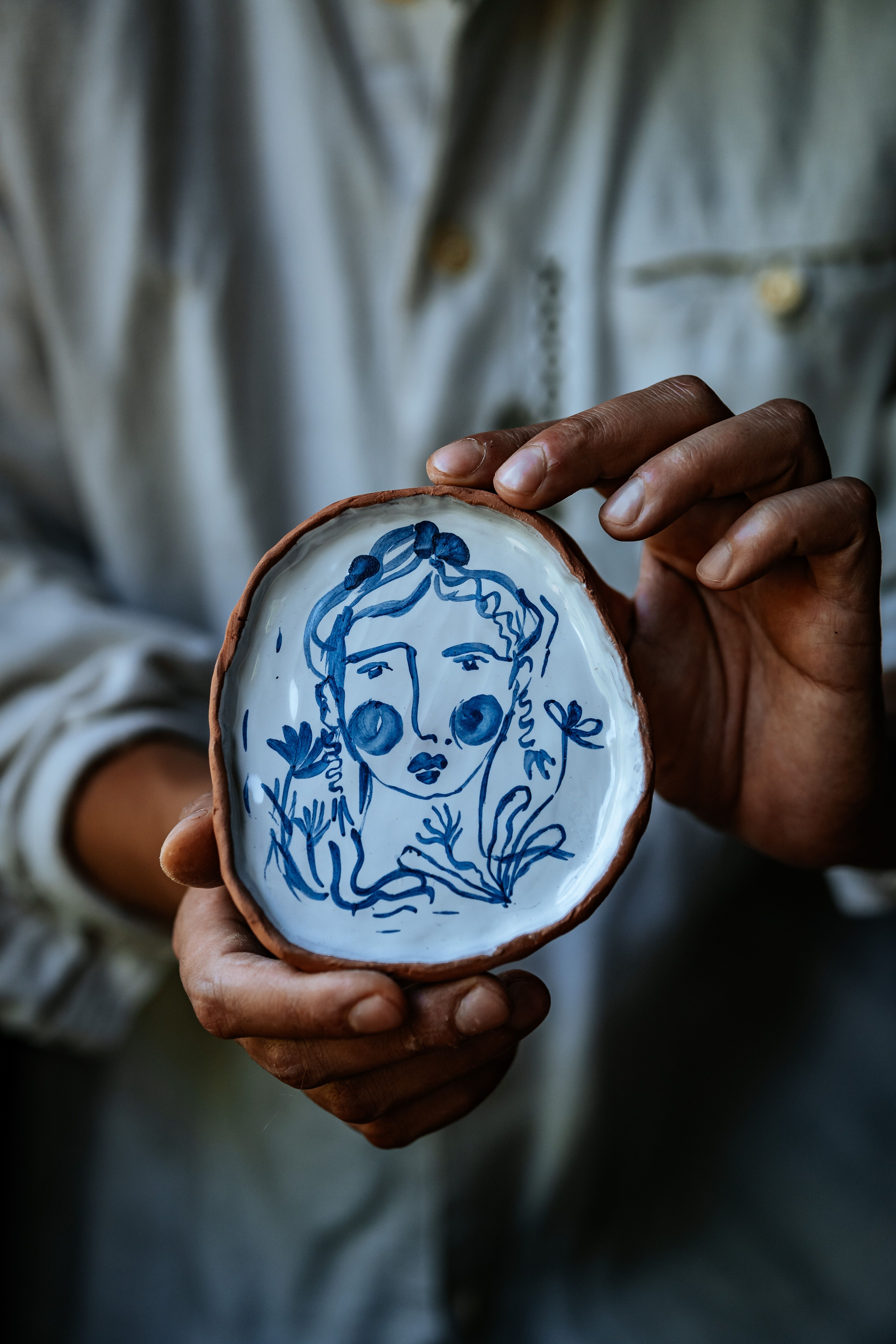 Handcrafted Ceramic Plate with Blue Face Design · Free Stock Photo