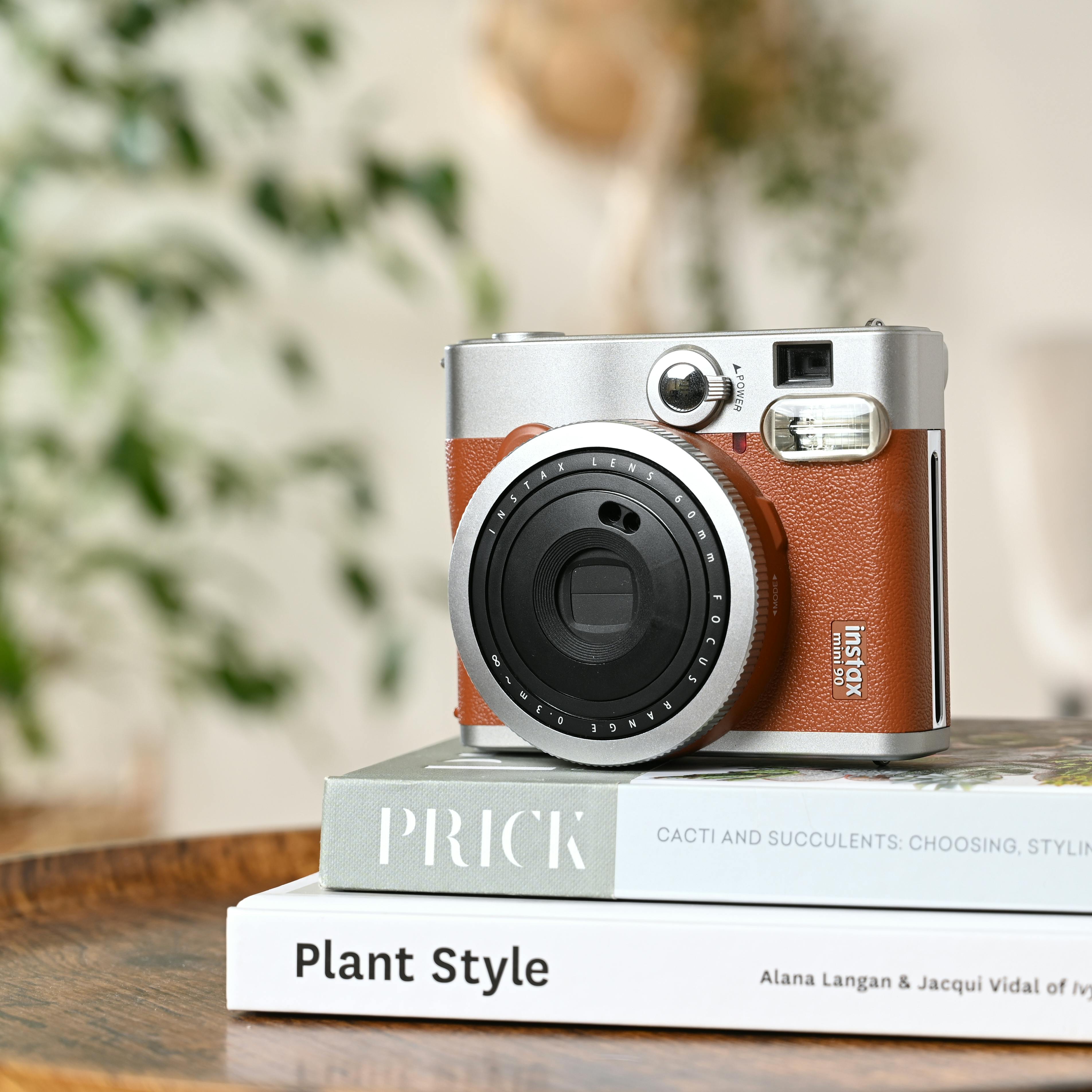 Retro Instant Camera on Stylish Book Display · Free Stock Photo