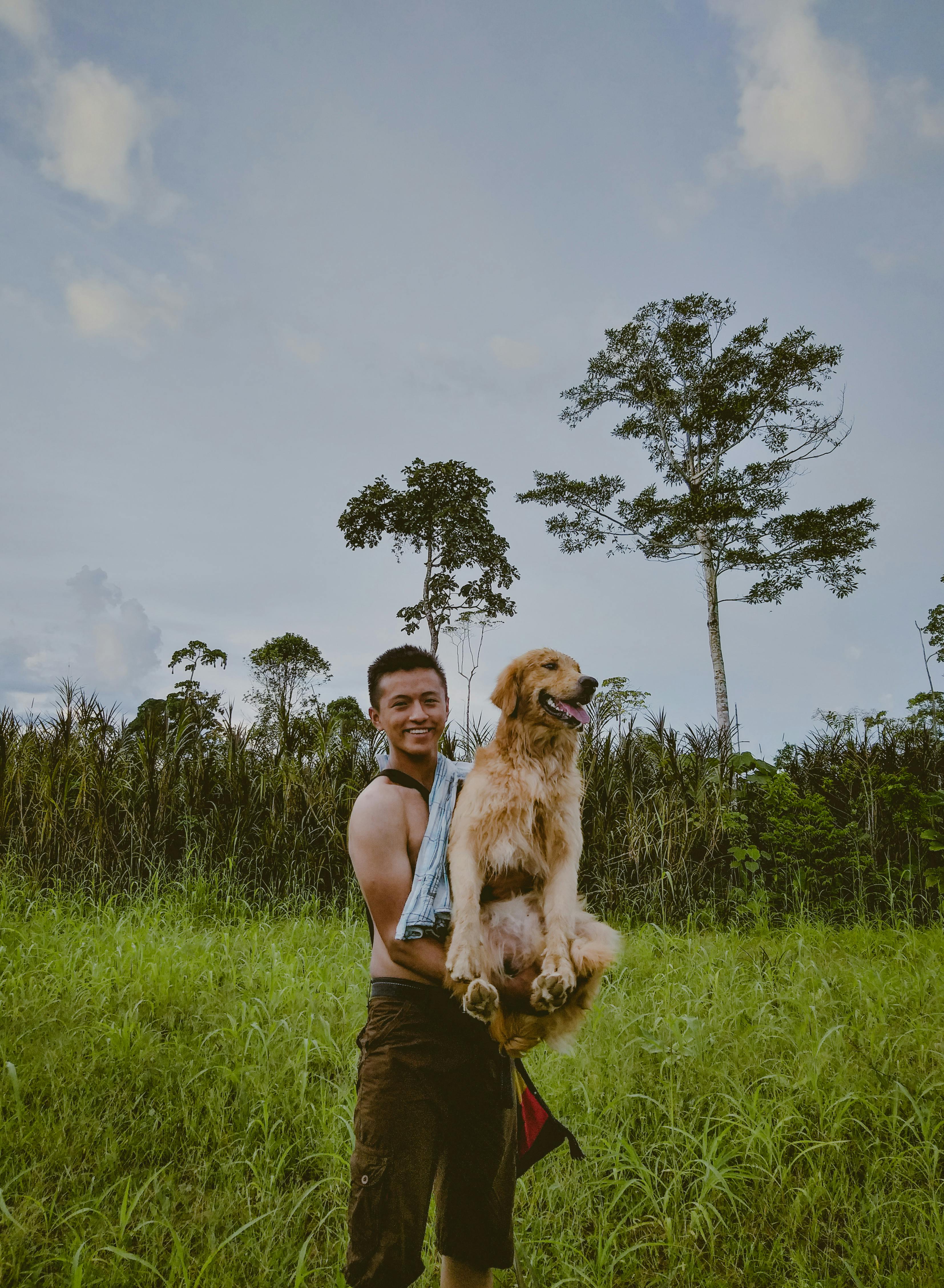 Photo Of Man Carrying Dog · Free Stock Photo