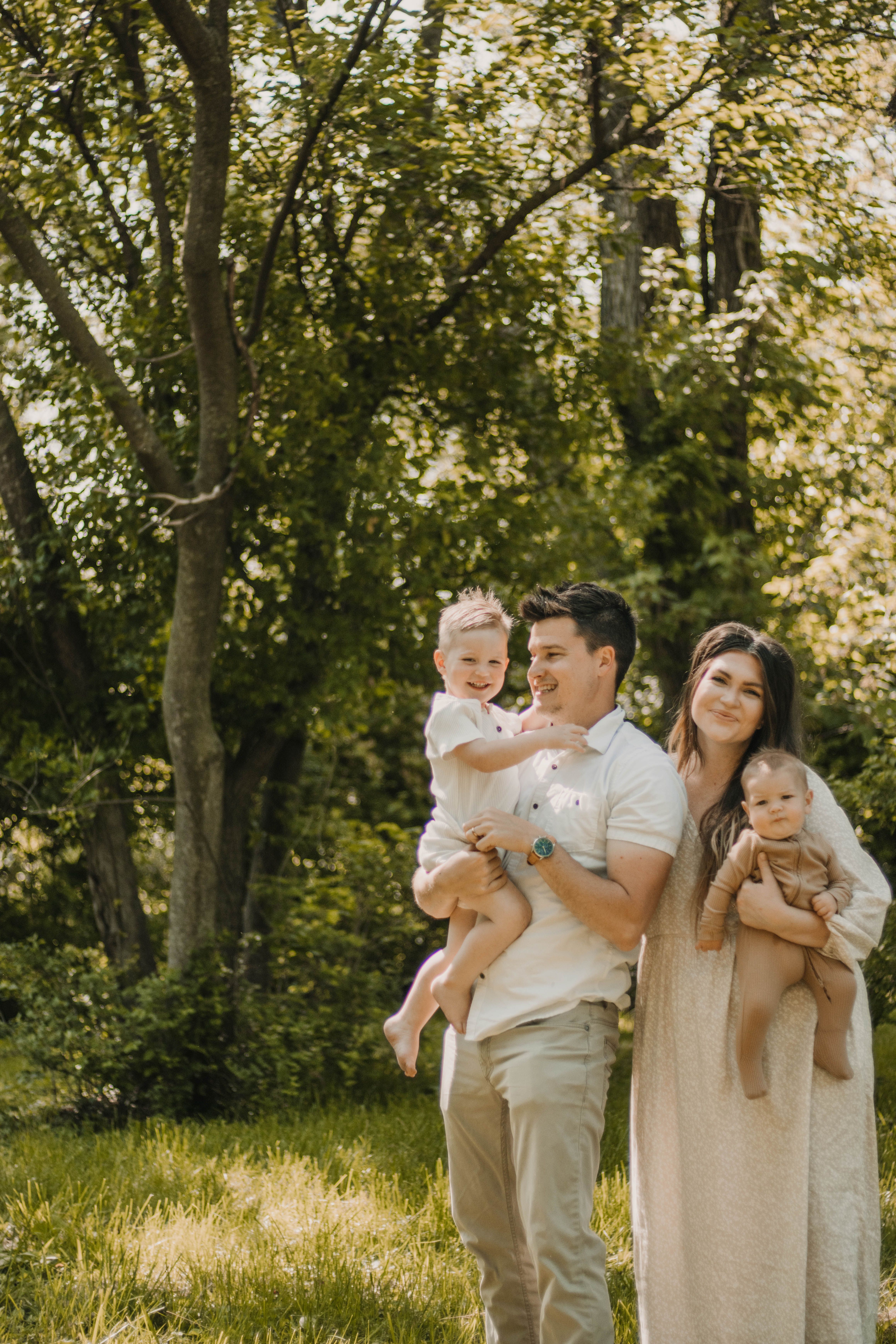 Heartwarming Family Portrait in Sunlit Forest · Free Stock Photo