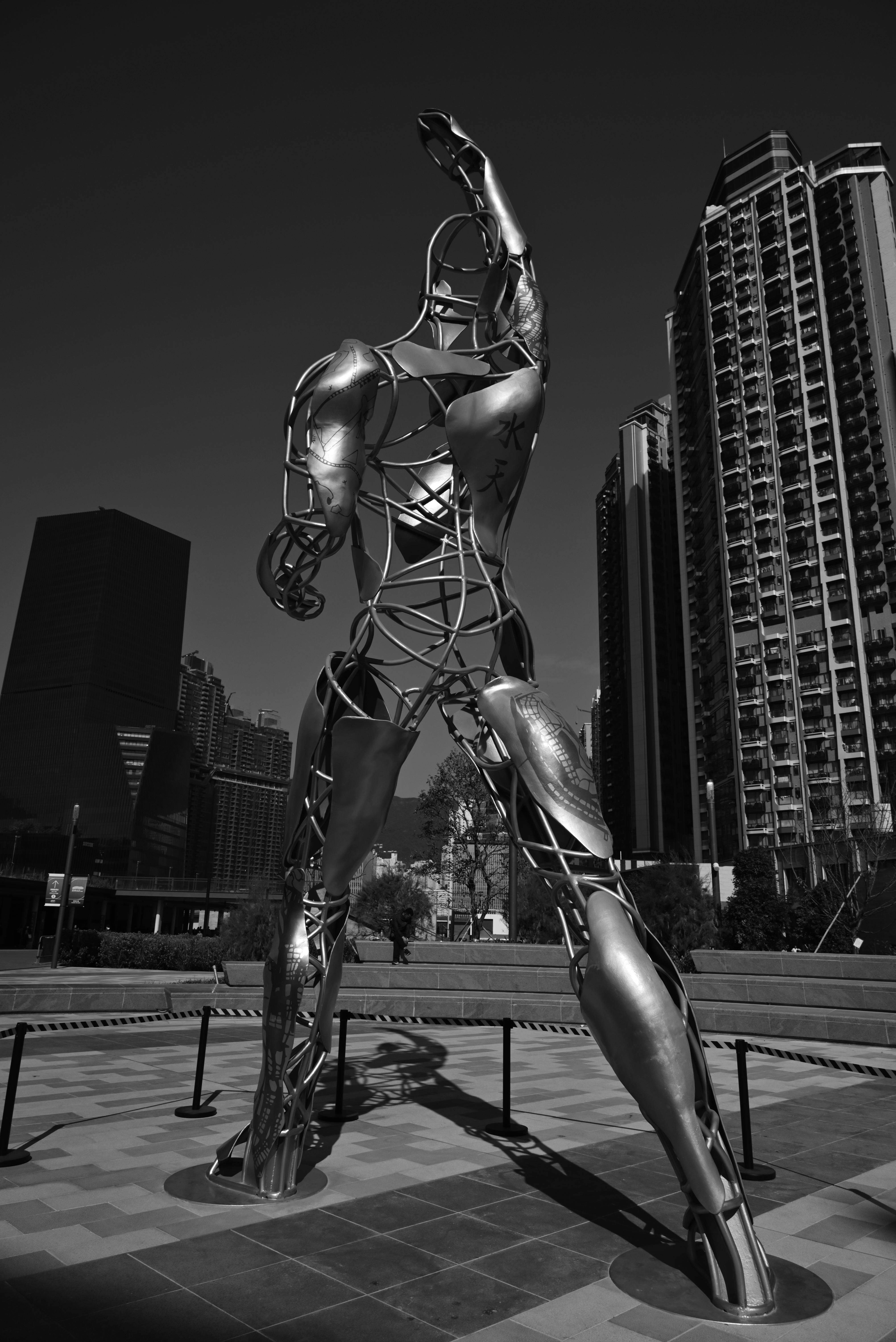 Dramatic Sculpture Against Urban Skyscrapers · Free Stock Photo