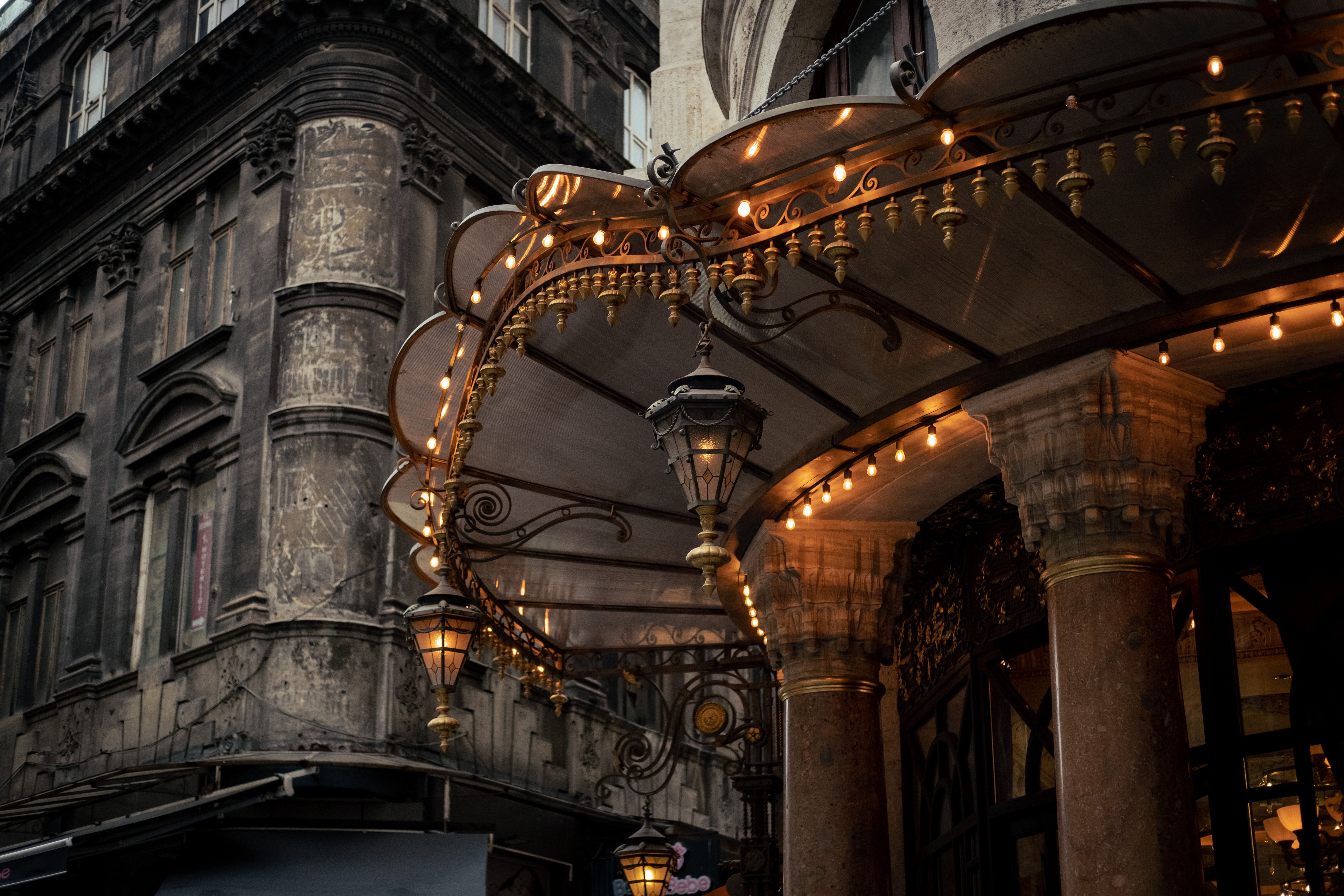 Historic building with ornate lanterns and canopy · Free Stock Photo