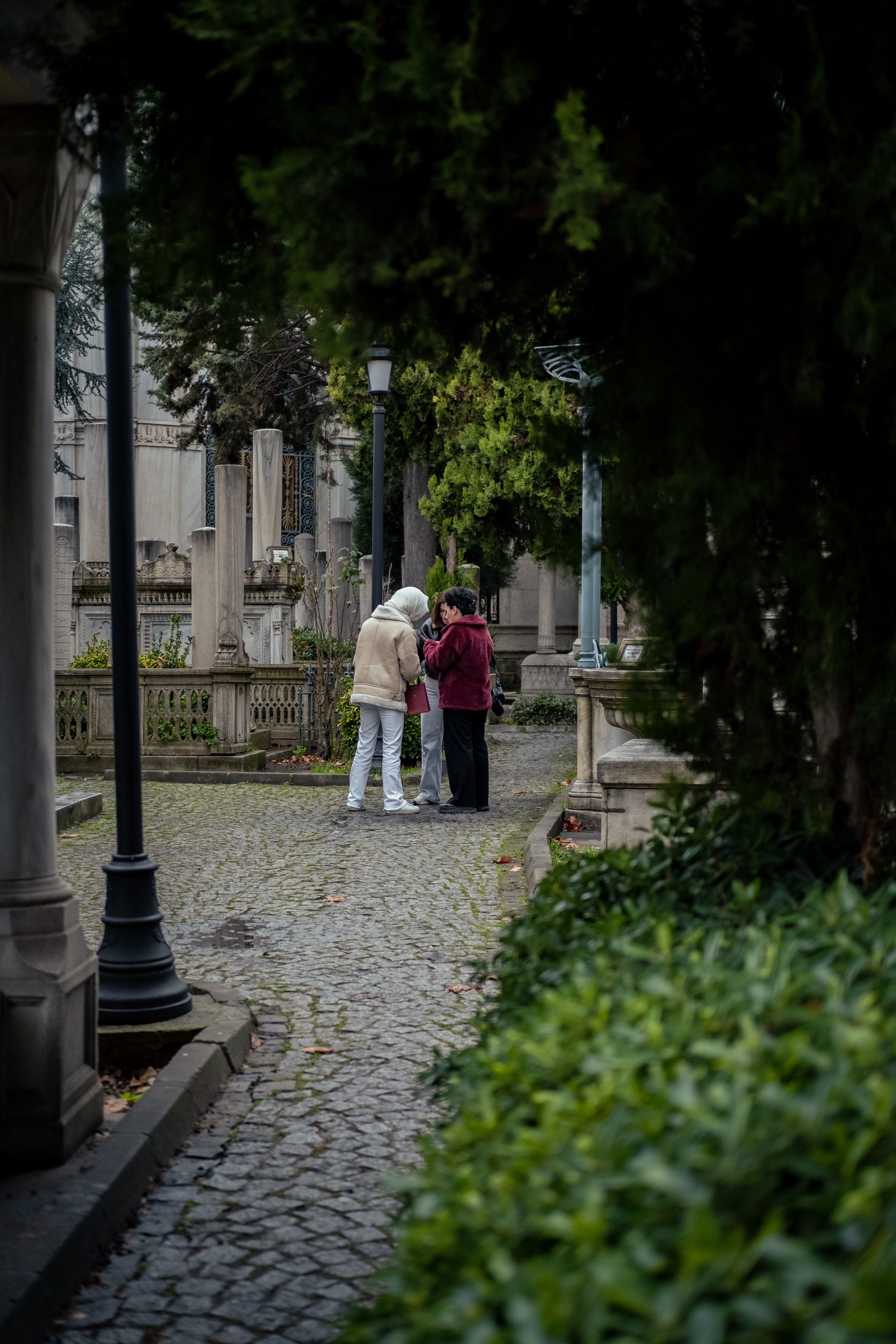 Two people in a peaceful cemetery setting · Free Stock Photo