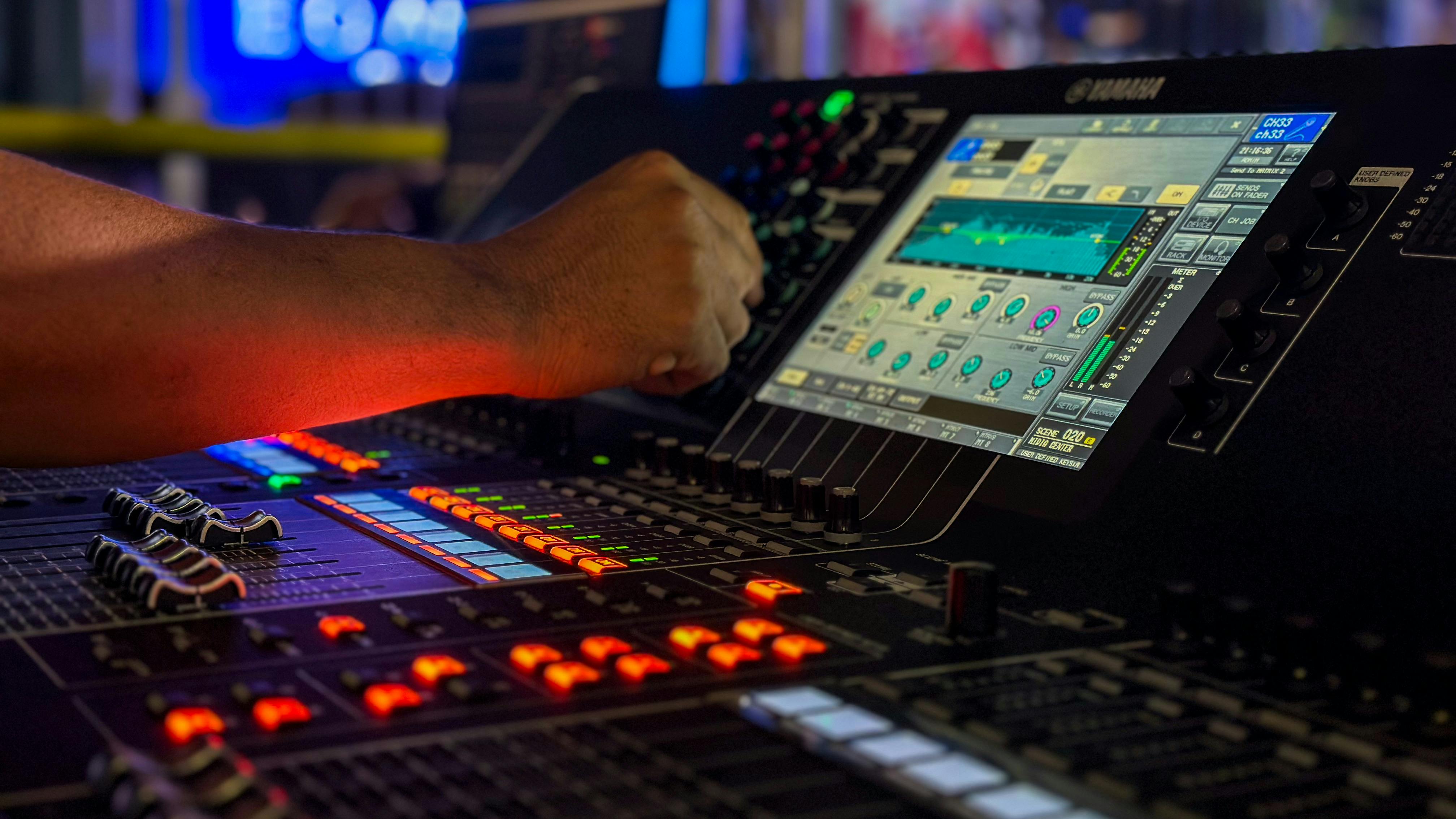 Audio Engineer Adjusting Mixing Console · Free Stock Photo