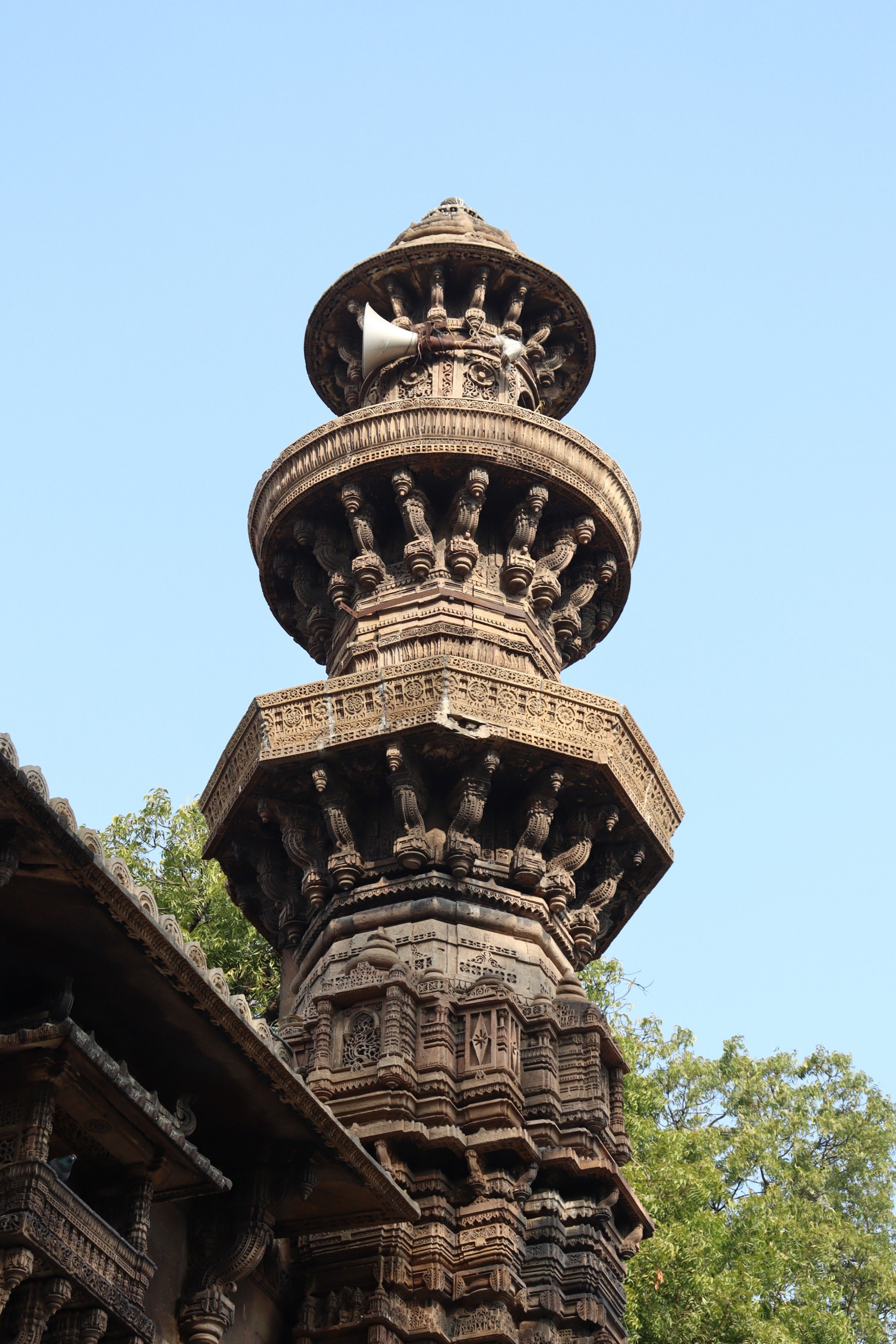 Intricate Stone Tower with Carvings Against Blue Sky · Free Stock Photo