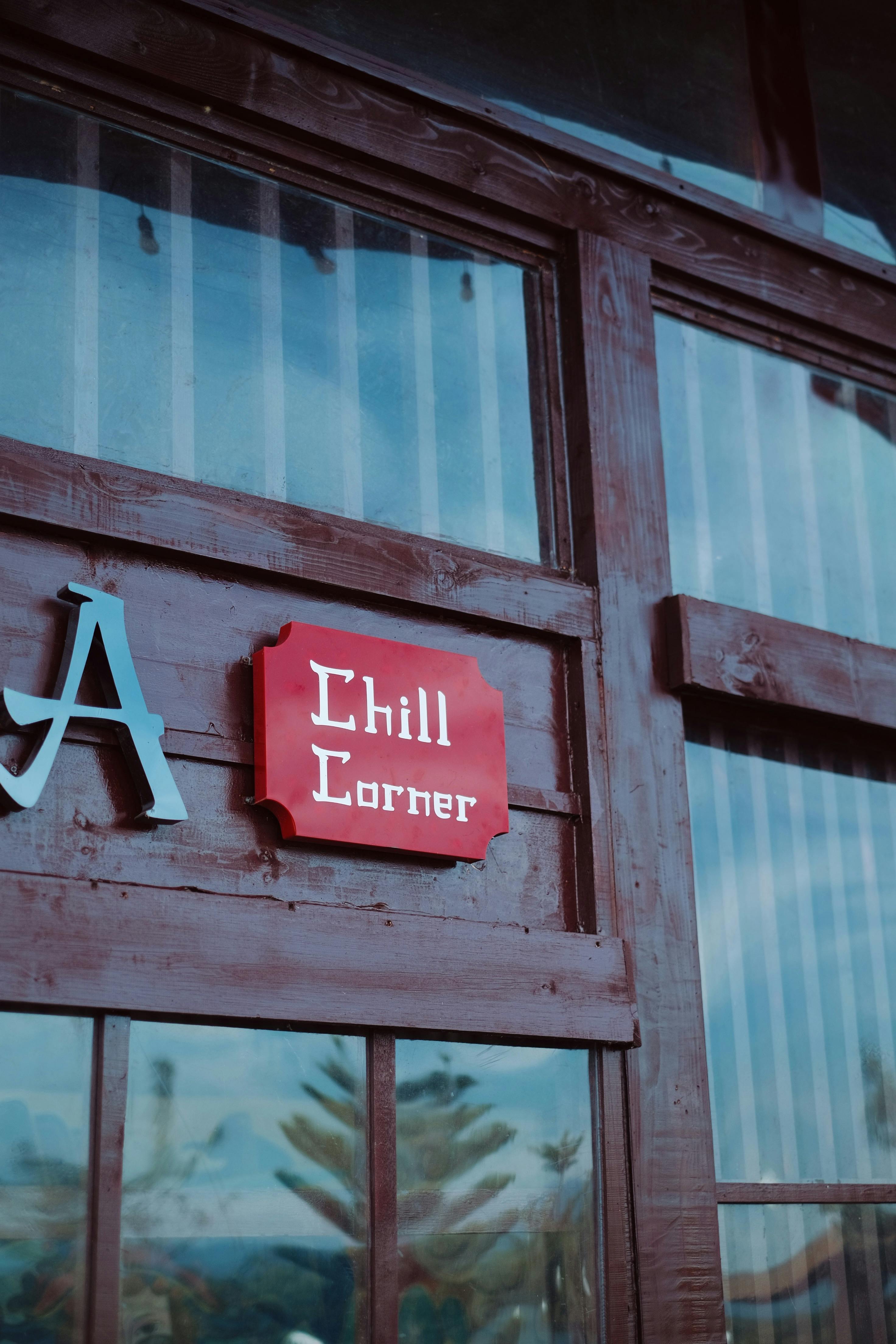 Chill Corner Sign on Rustic Wooden Building · Free Stock Photo