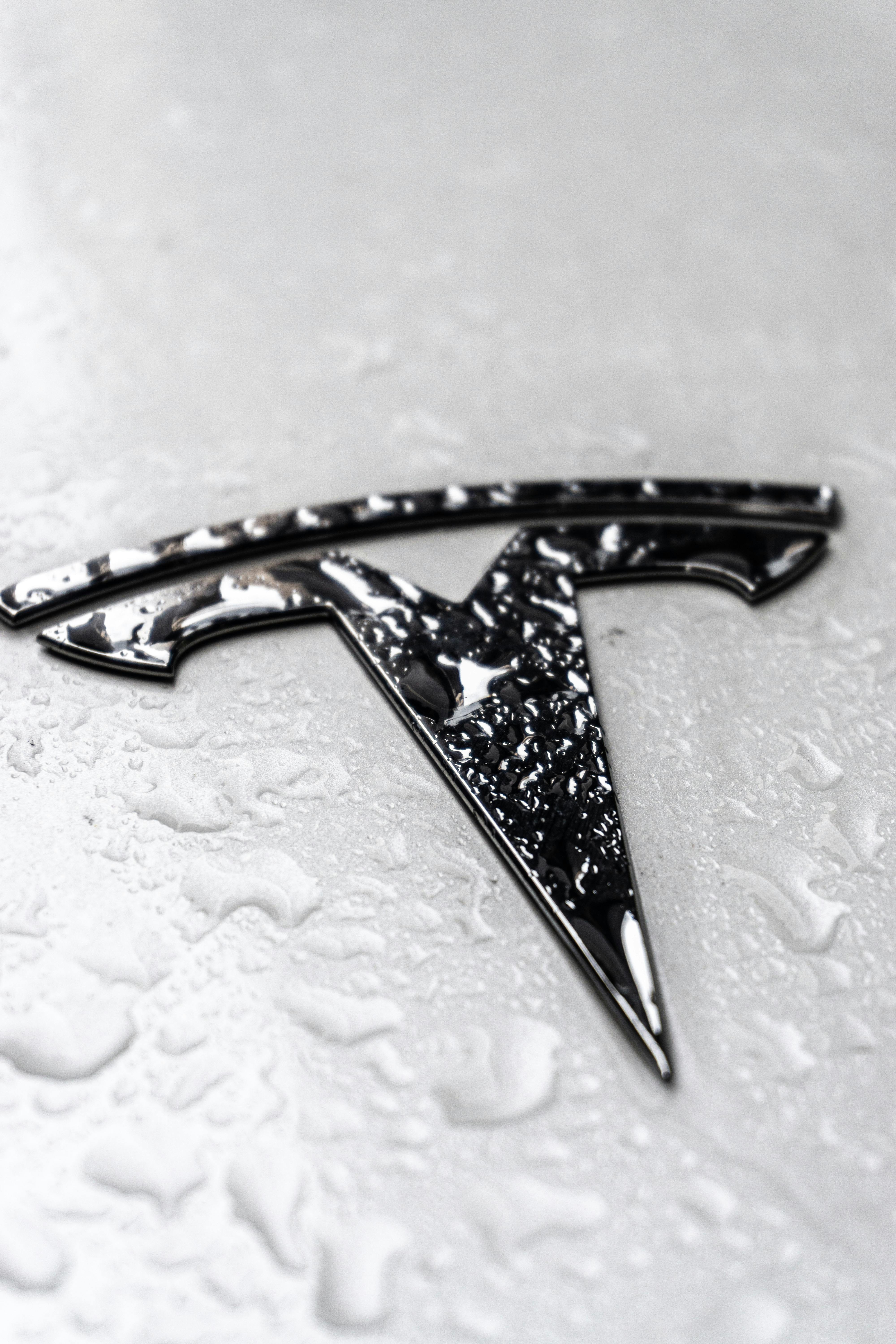 Close-Up of Tesla Emblem with Water Droplets · Free Stock Photo
