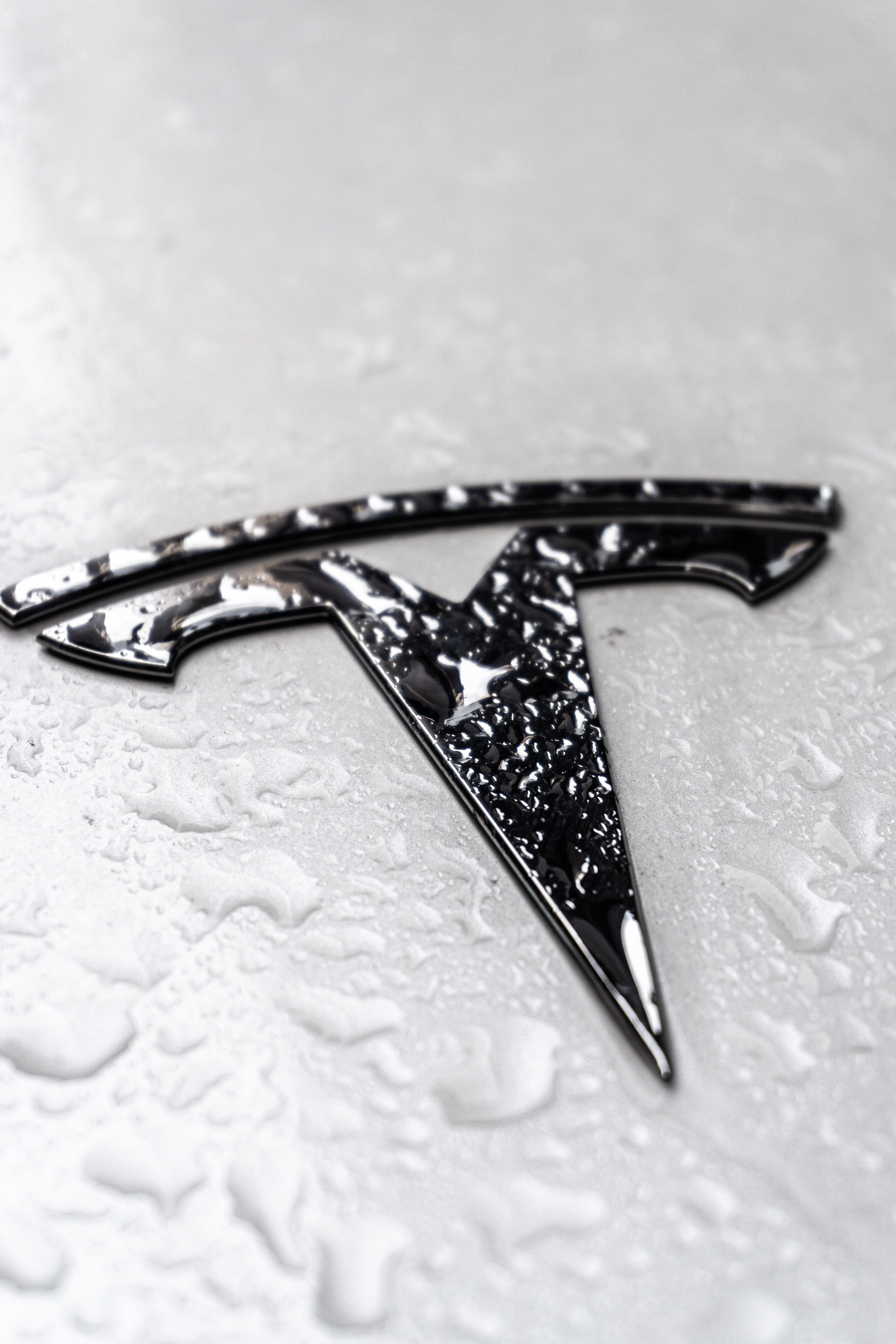 Close Up Lambang Tesla Dengan Tetesan Air · Foto Stok Gratis