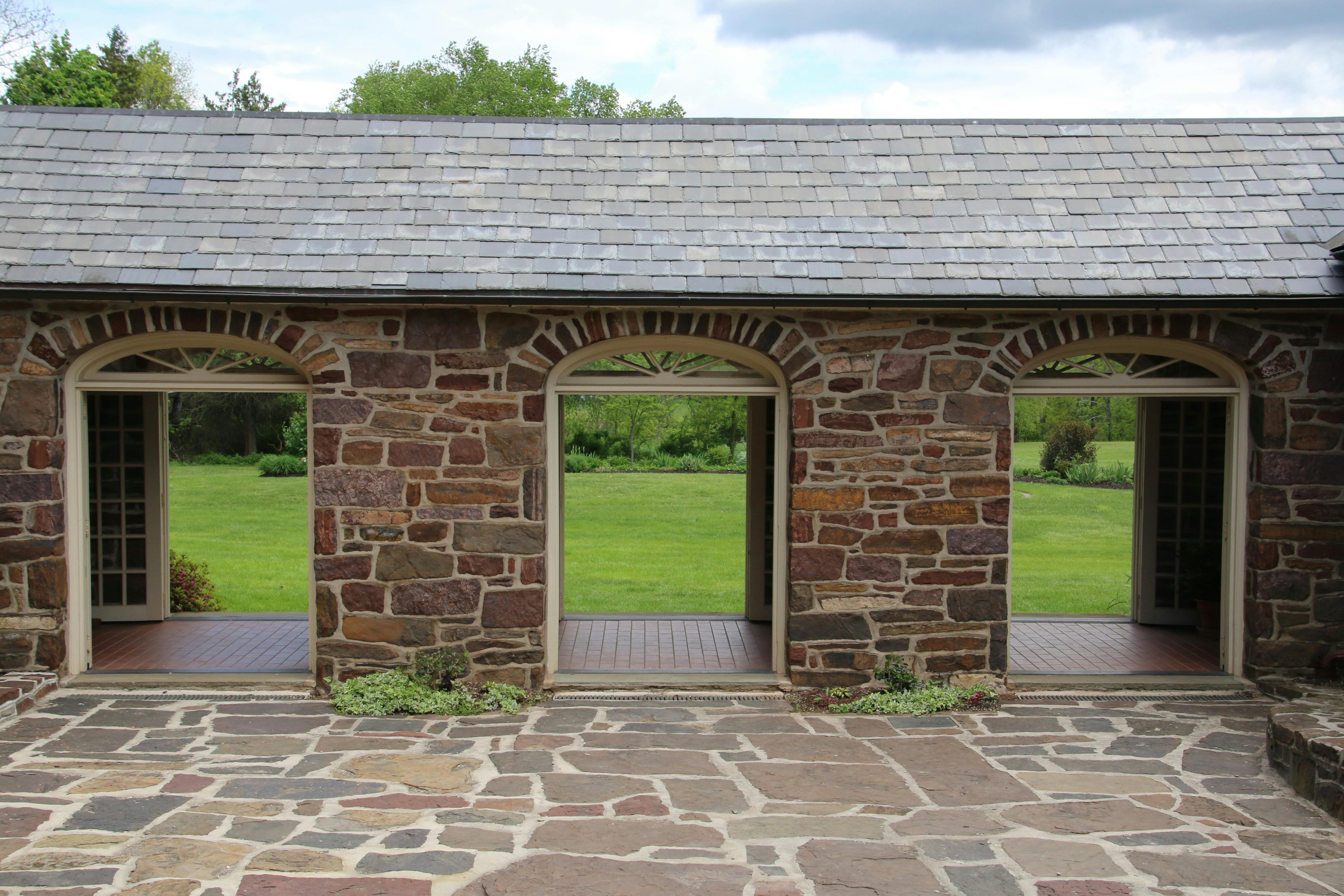 Rustic Stone Building with Open Arched Doors · Free Stock Photo