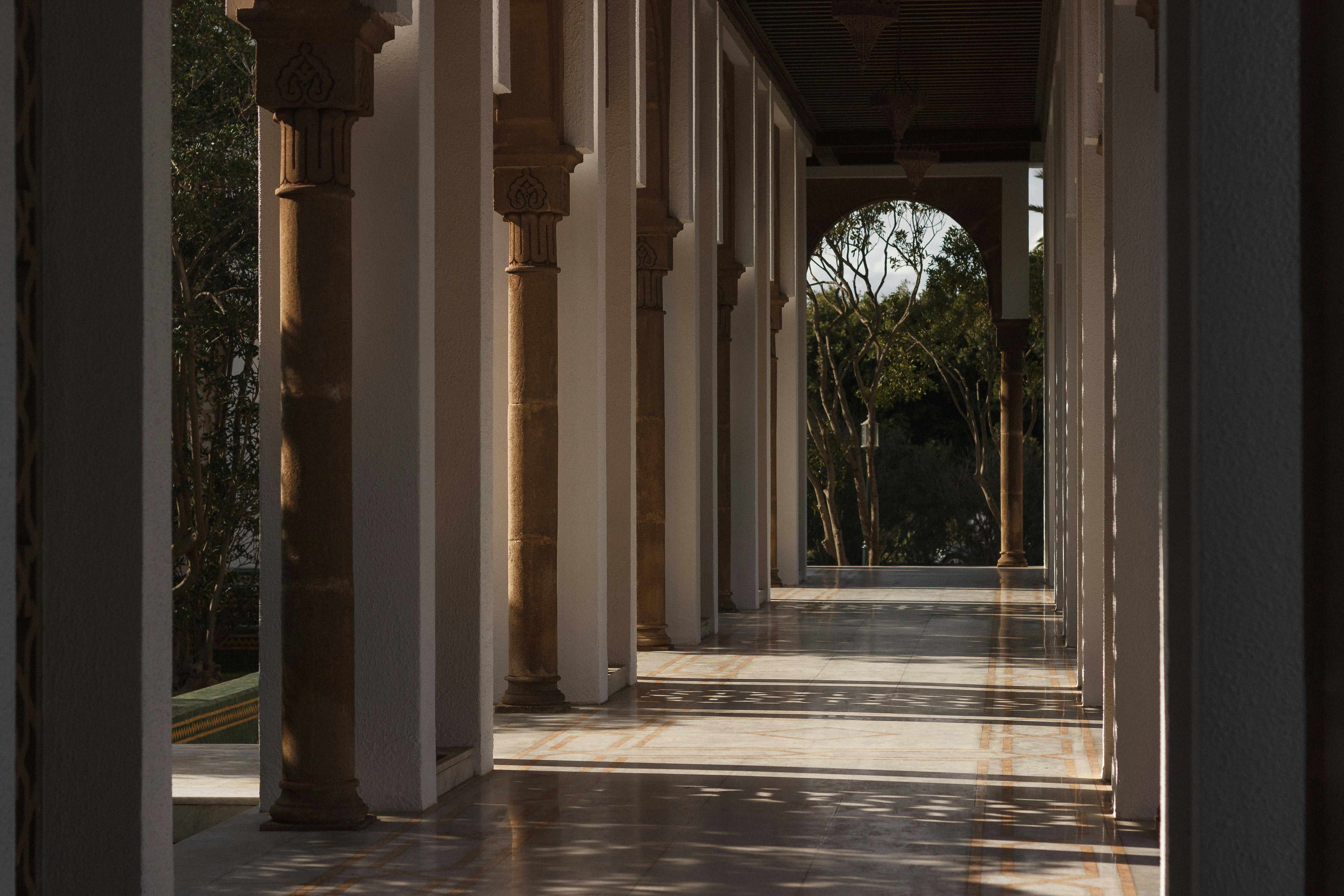 Elegant Sunlit Corridor with Pillars · Free Stock Photo