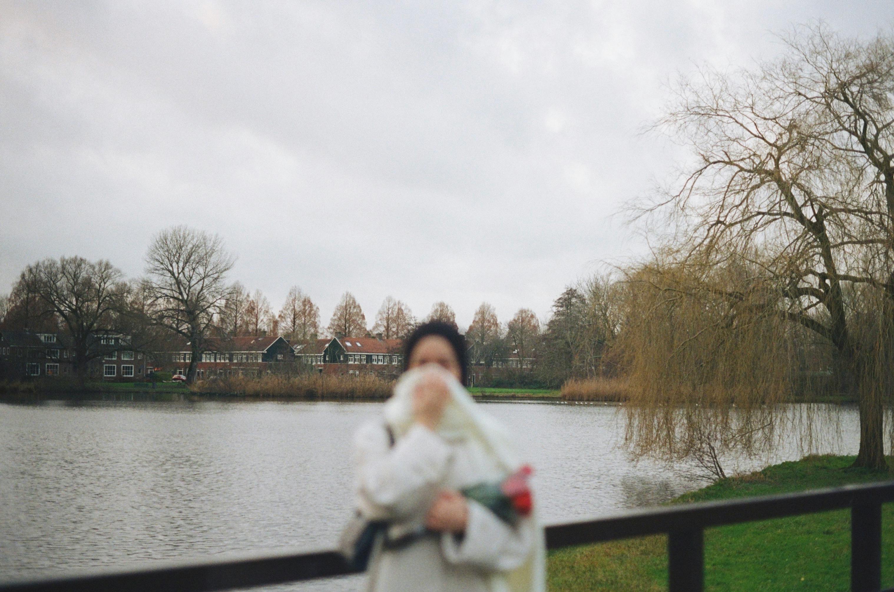 Blurry Figure by a Tranquil Lakeside · Free Stock Photo