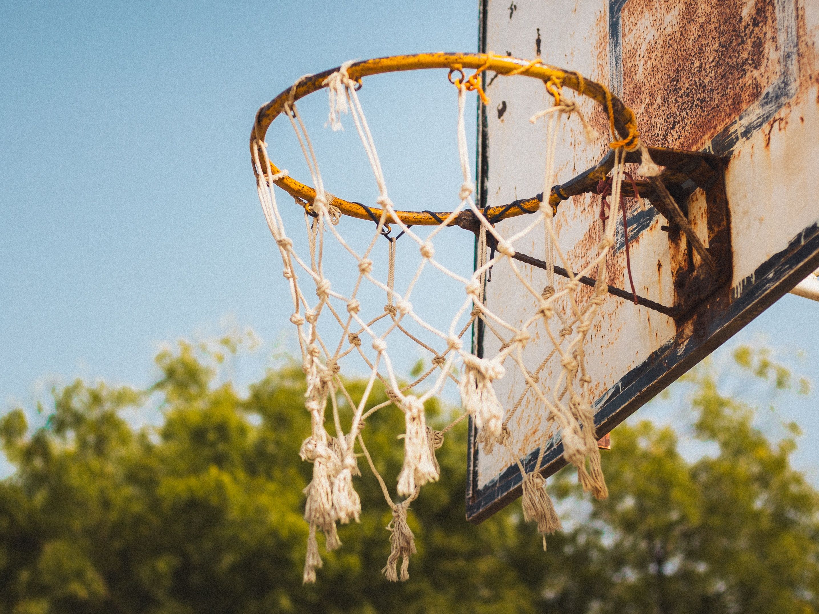 Rustic outdoor basketball hoop on sunny day · Free Stock Photo