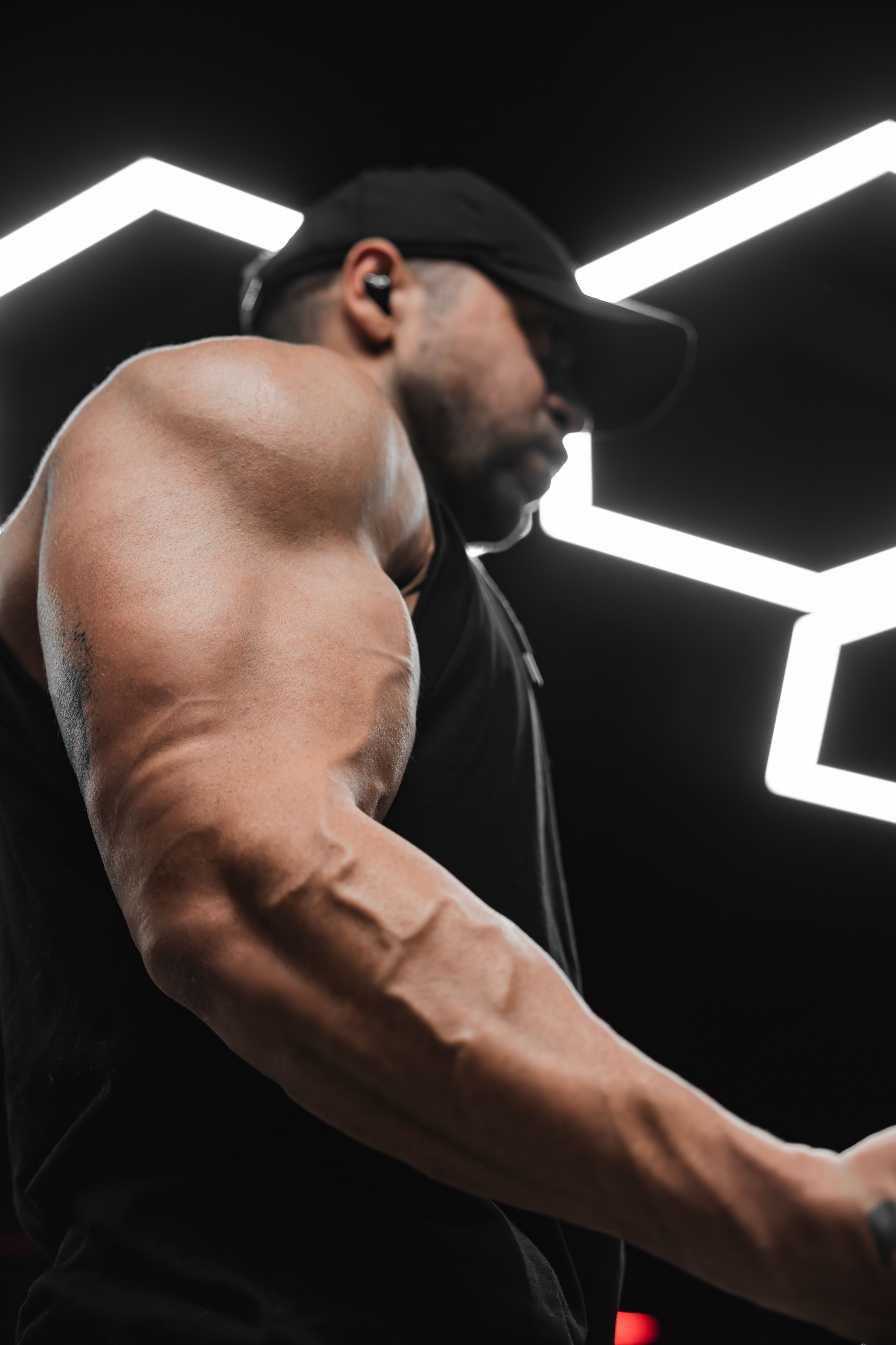 Close-Up of Muscular Arm and Modern Lighting · Free Stock Photo