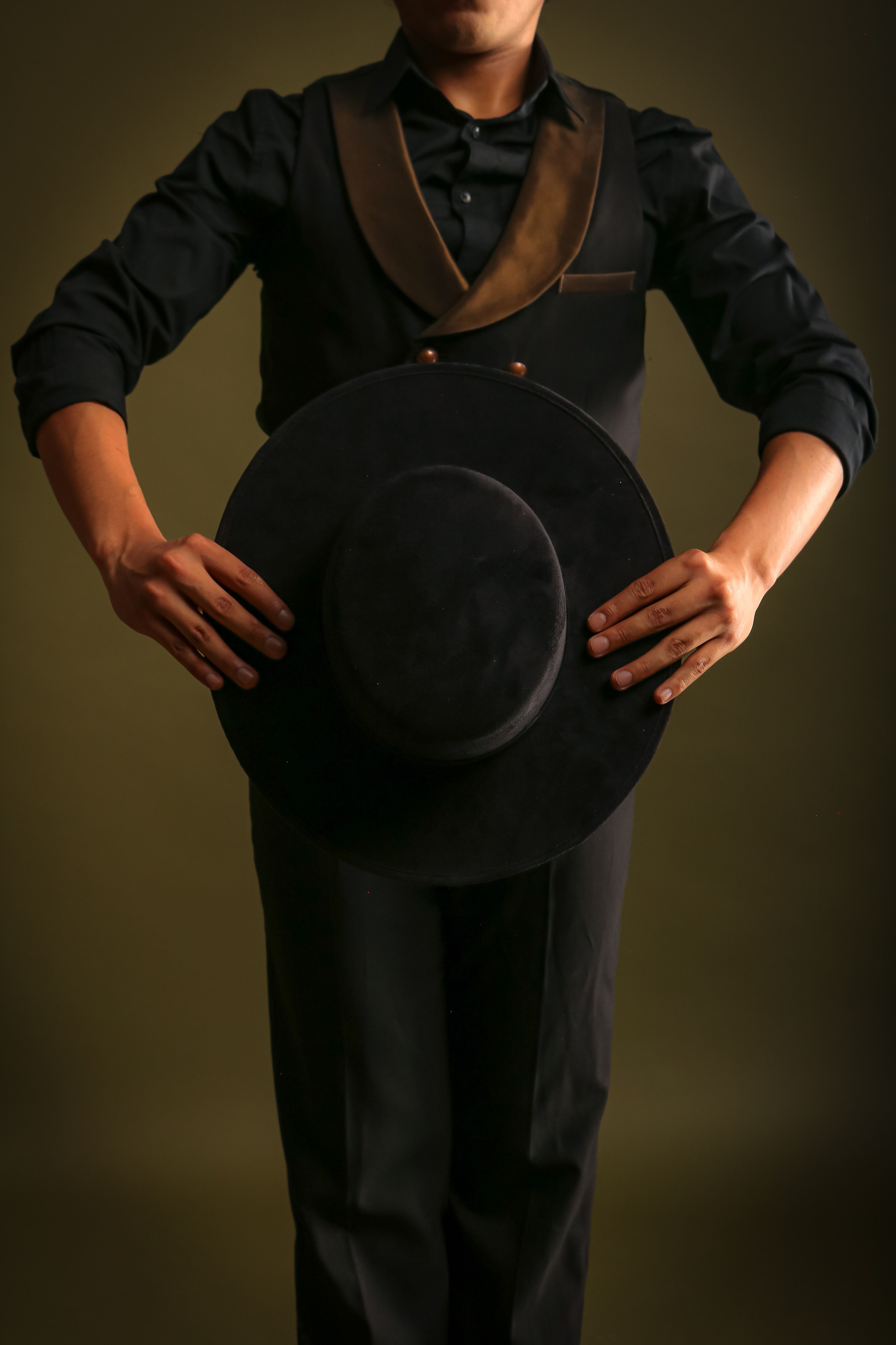 Elegant Man Holding Hat in Stylish Attire · Free Stock Photo