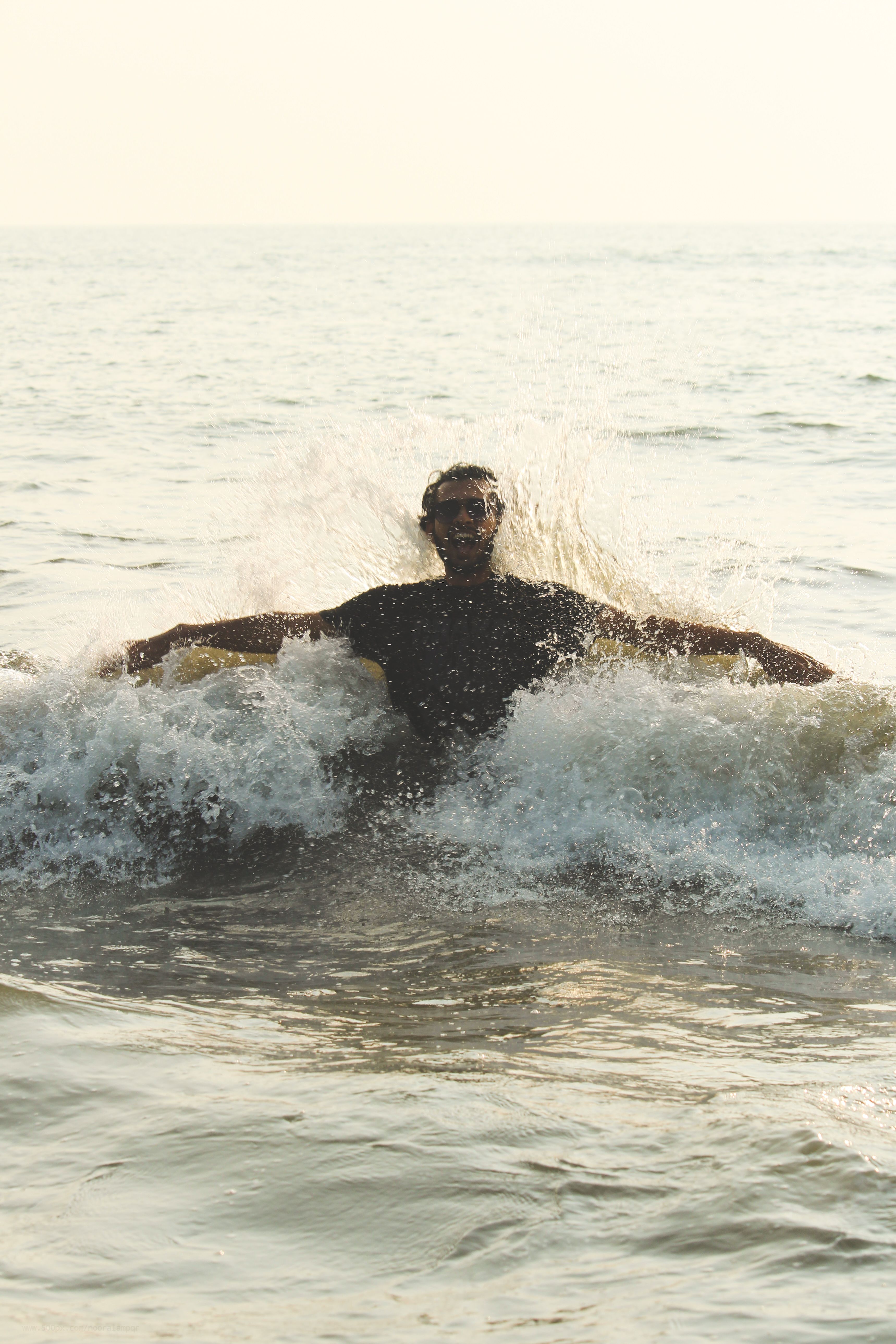 Man Enjoying Waves at the Beach at Sunset · Free Stock Photo