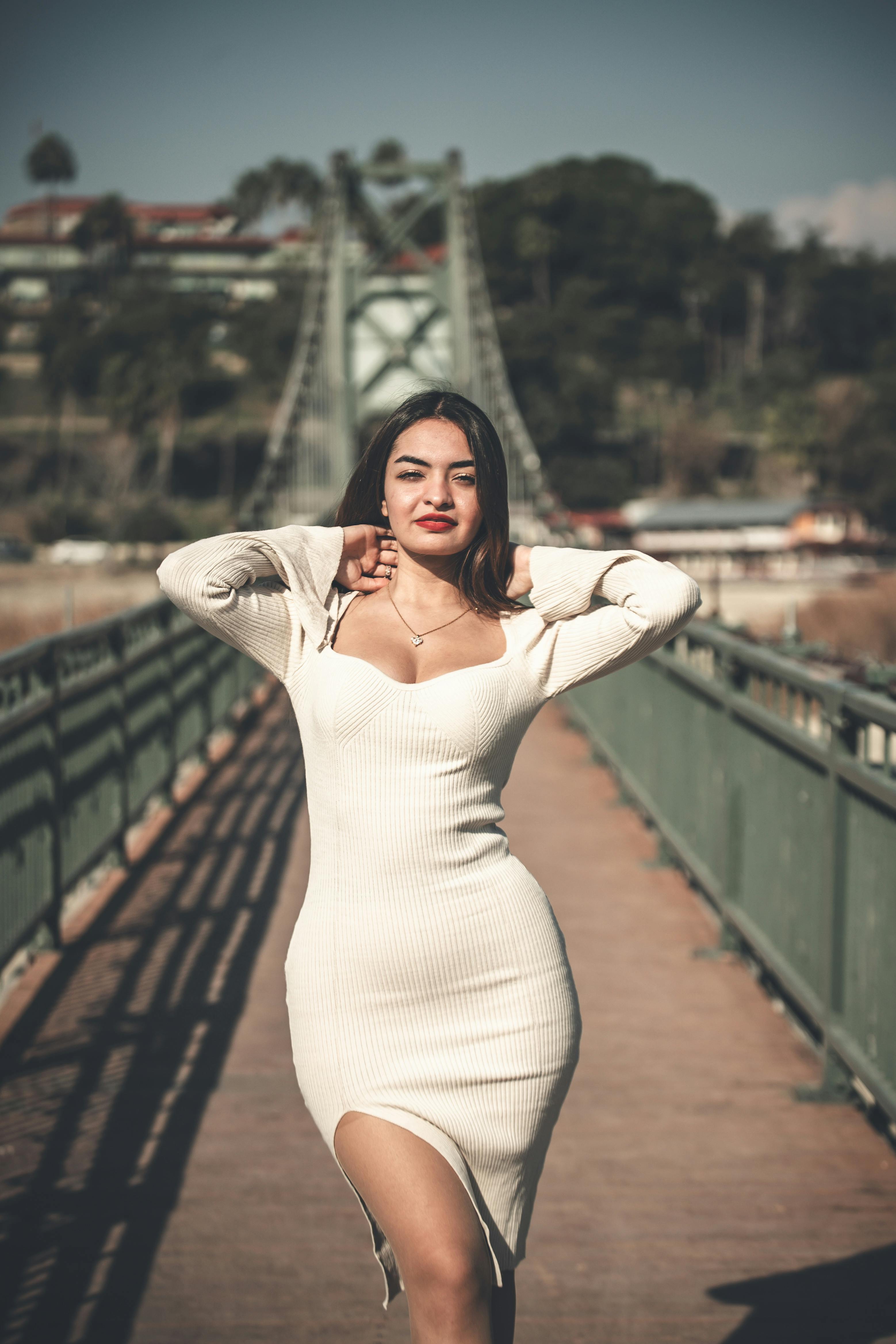 Confident Woman Posing on Bridge in Sunlight · Free Stock Photo
