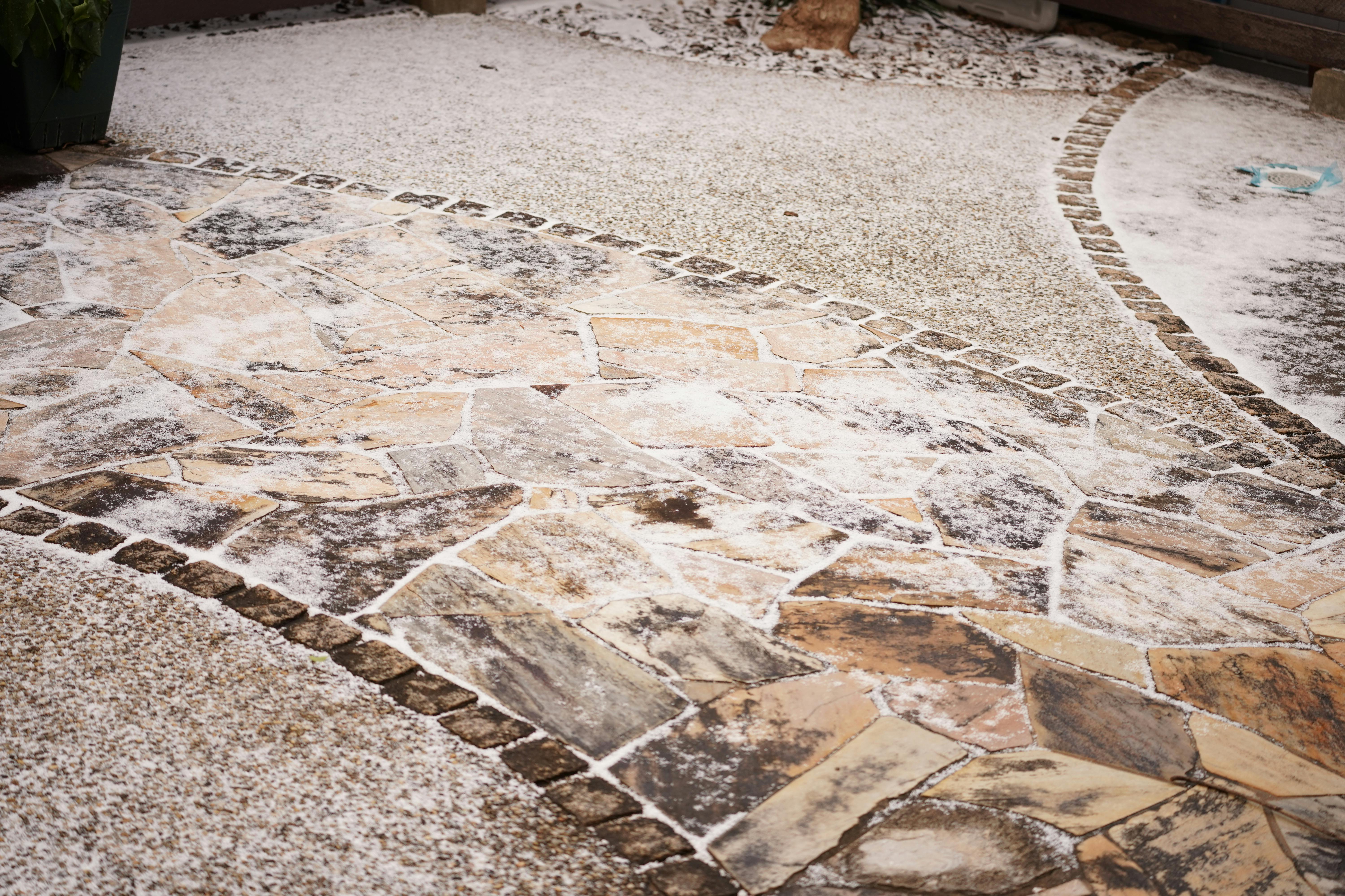 Snow-dusted stone patio with intricate design · Free Stock Photo