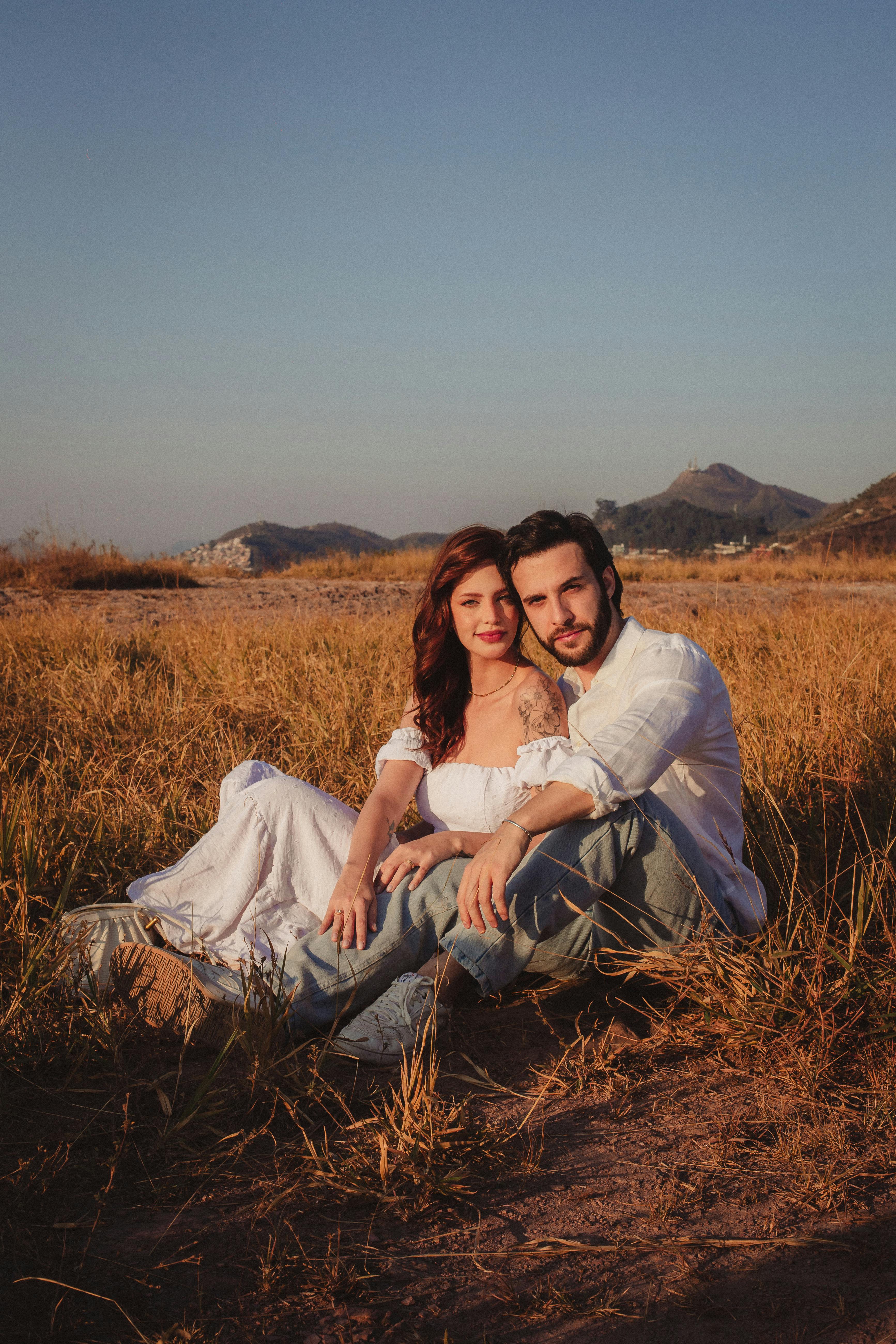 浪漫的情侣坐在阳光明媚的田野里 · 免费素材图片