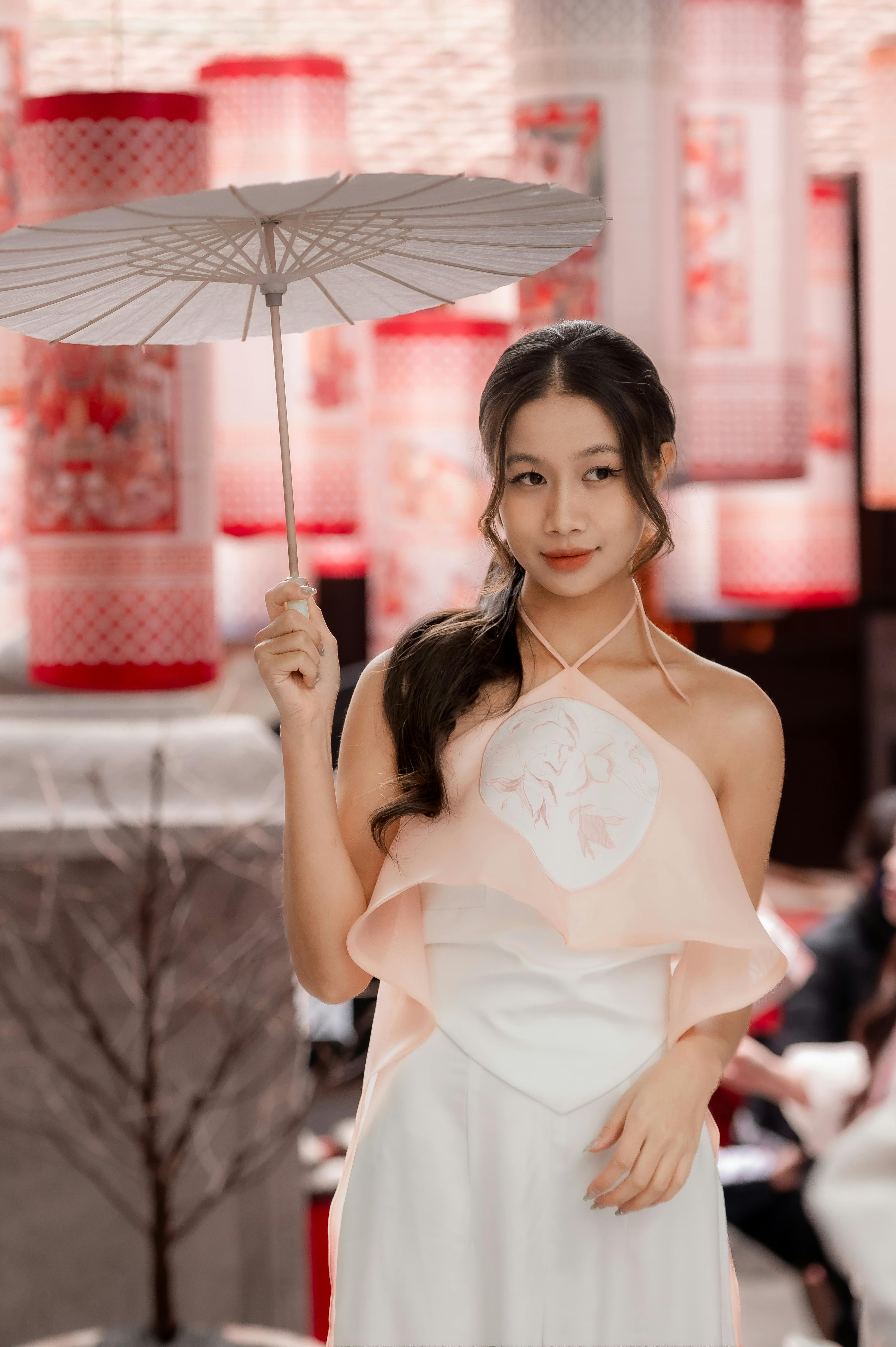 Elegant Woman with Parasols in Traditional Setting · Free Stock Photo