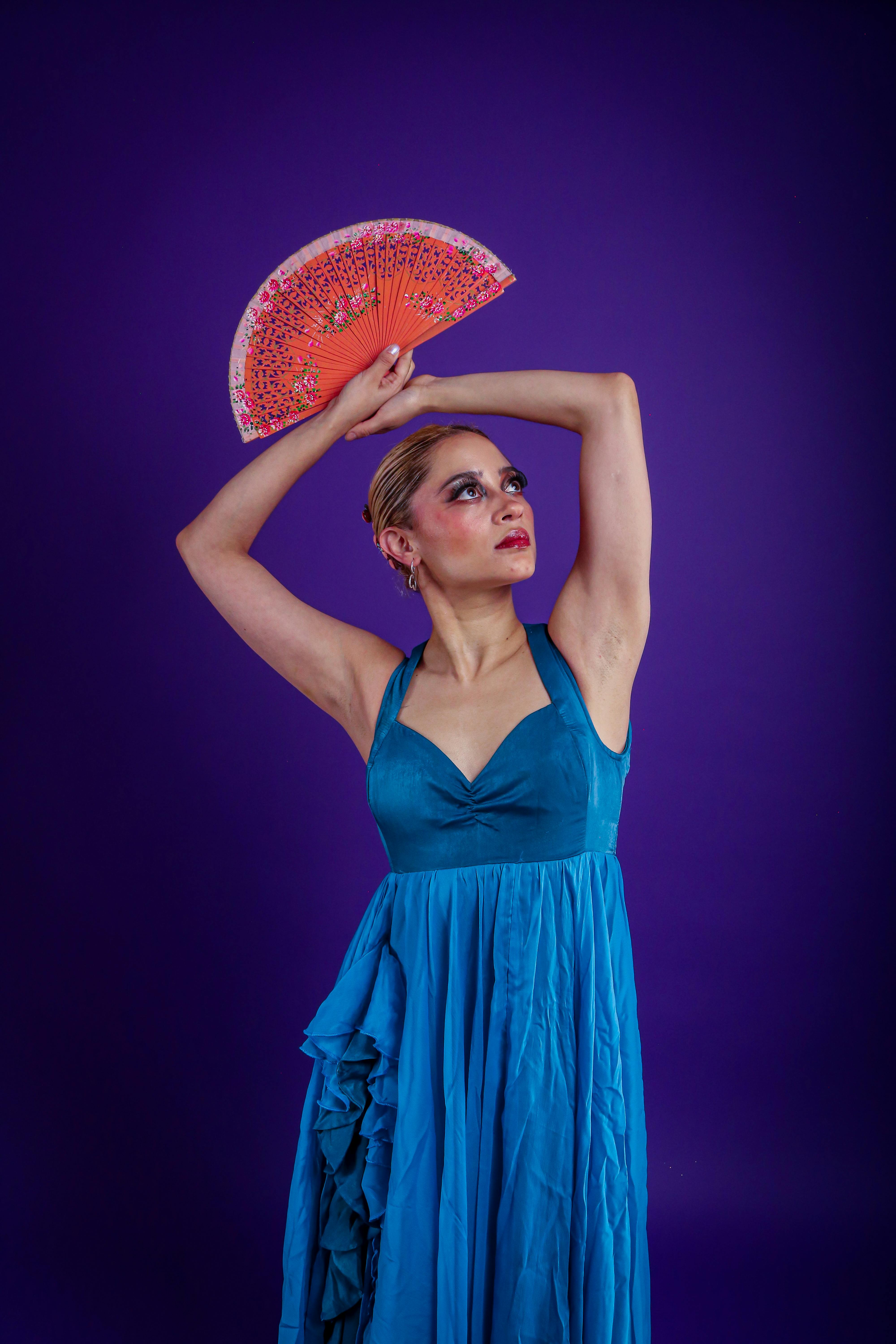 Graceful dancer with fan in vibrant blue dress · Free Stock Photo