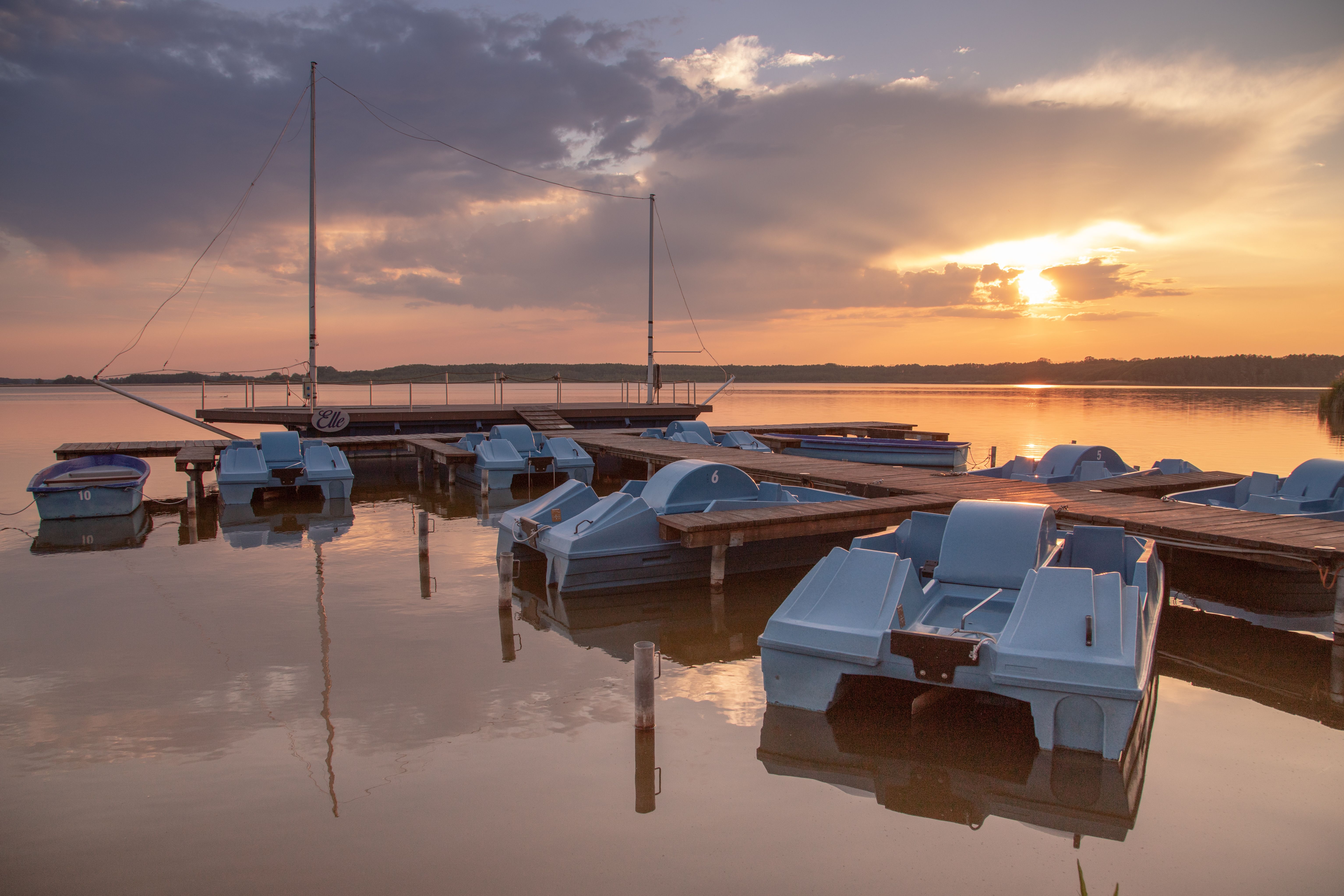 Peaceful Lake Dock with Paddle Boats at Sunset · Free Stock Photo