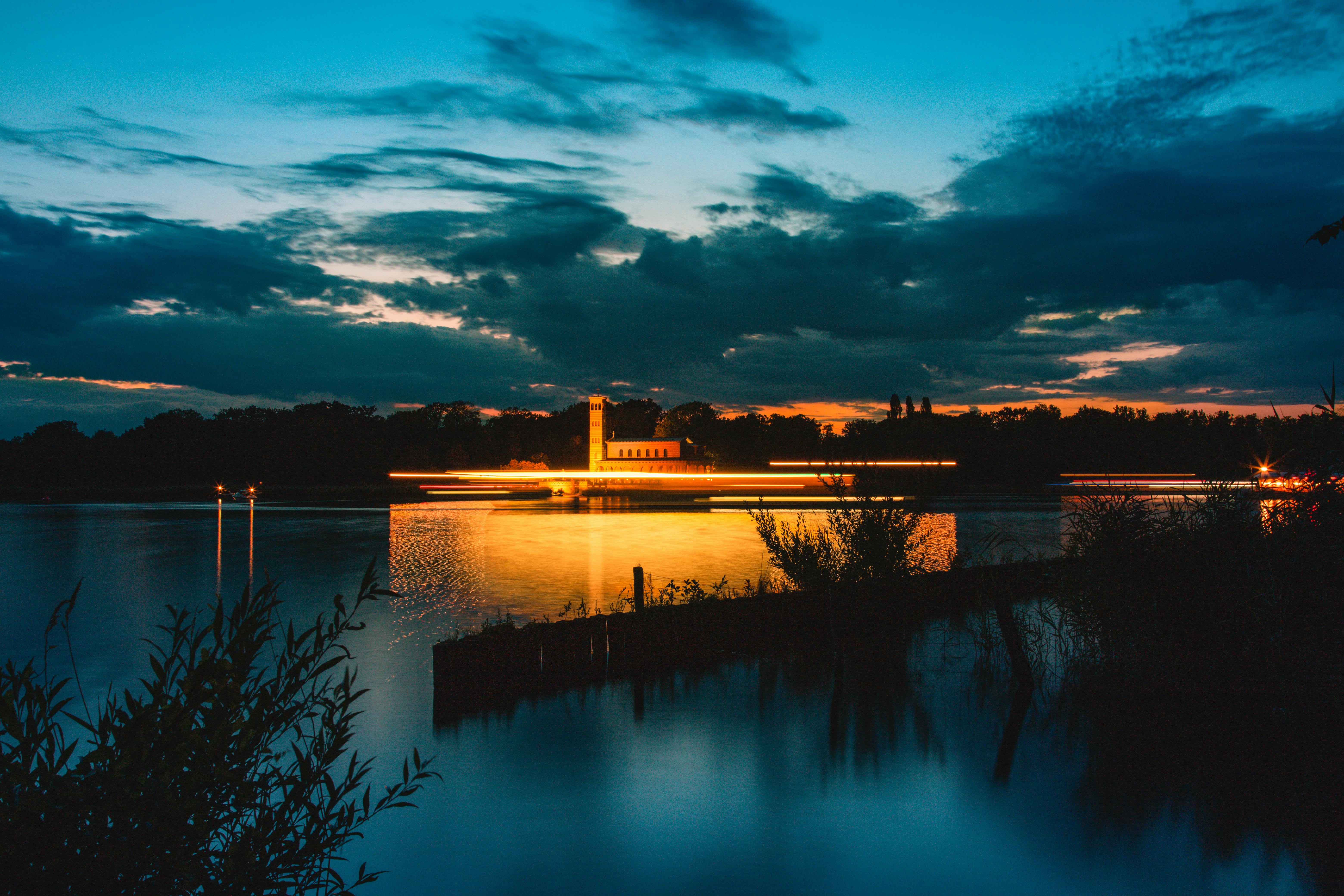 Riverside Sunset with Light Trails and Clouds · Free Stock Photo