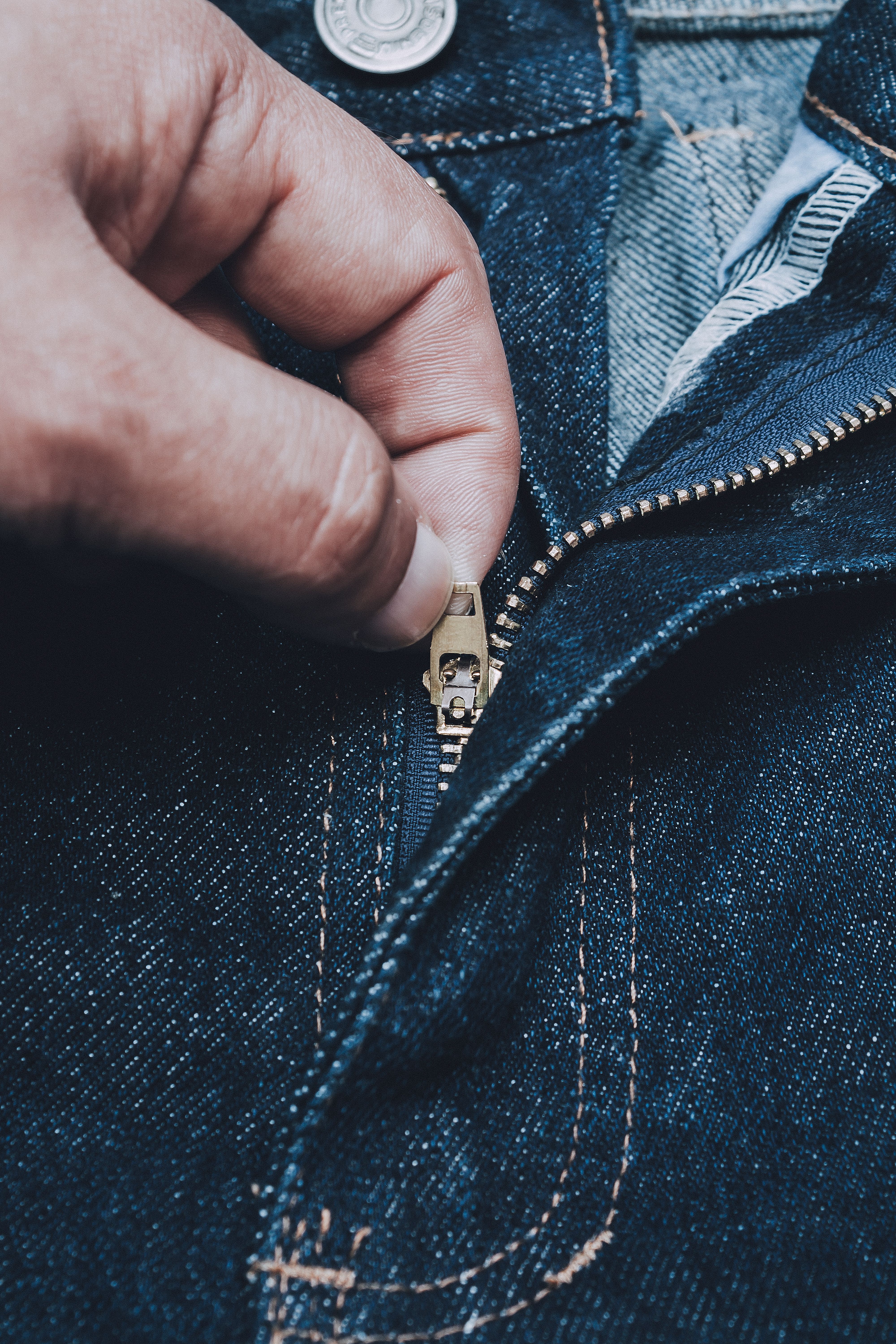 Close-up of Hand Zipping Denim Jeans · Free Stock Photo