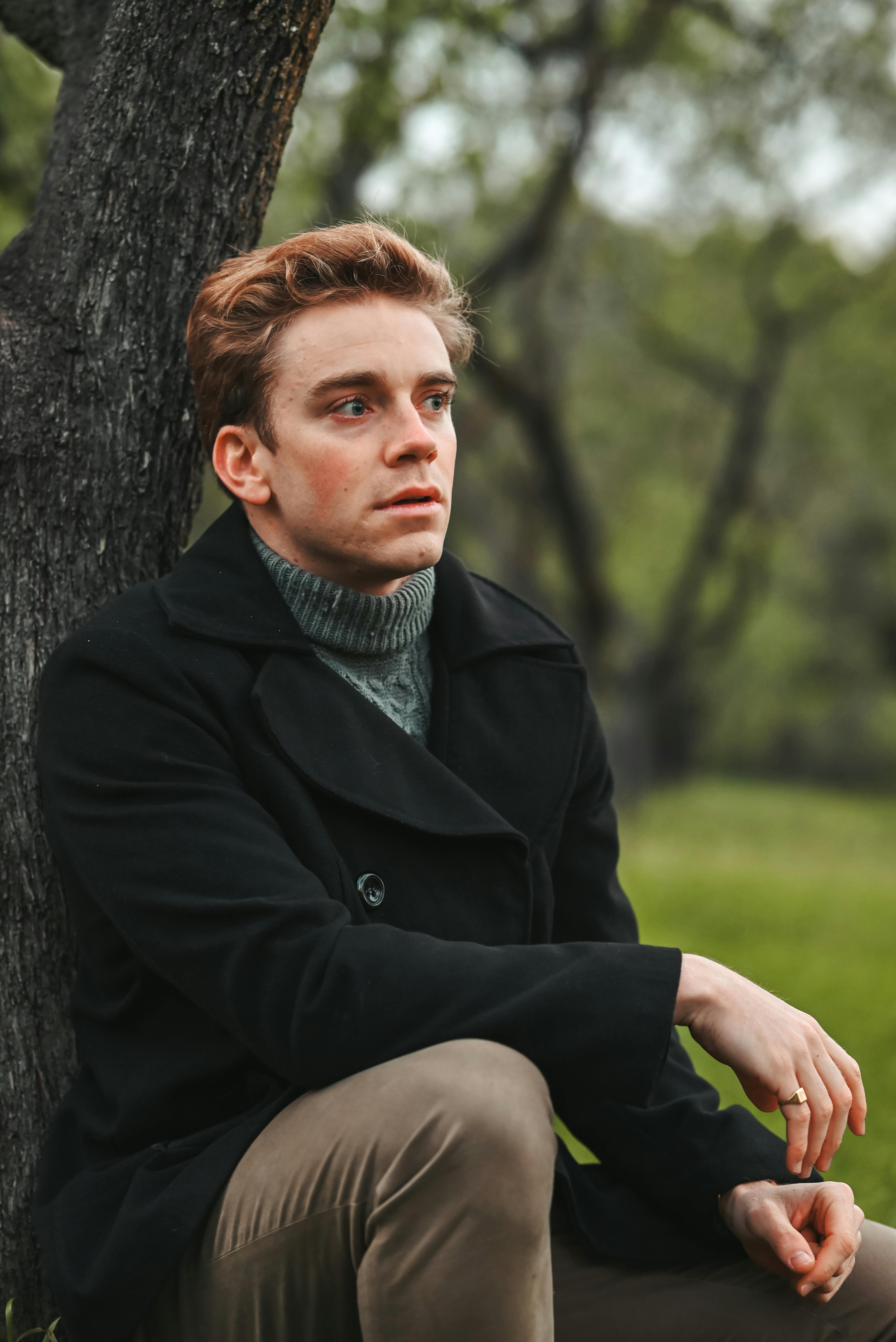 Thoughtful Man Sitting Against Tree in Autumn · Free Stock Photo