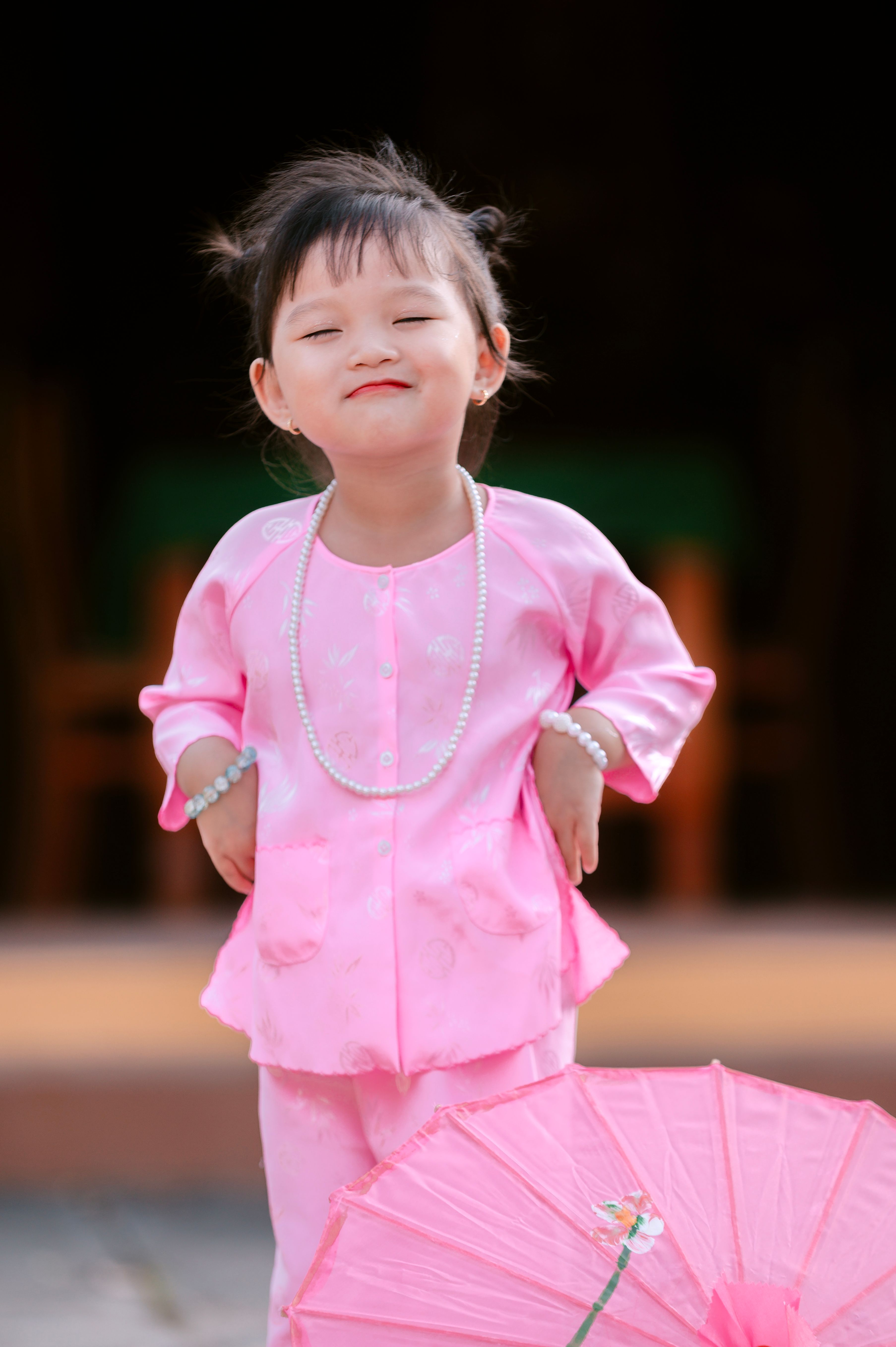 Charming Child in Traditional Pink Attire Smiling · Free Stock Photo