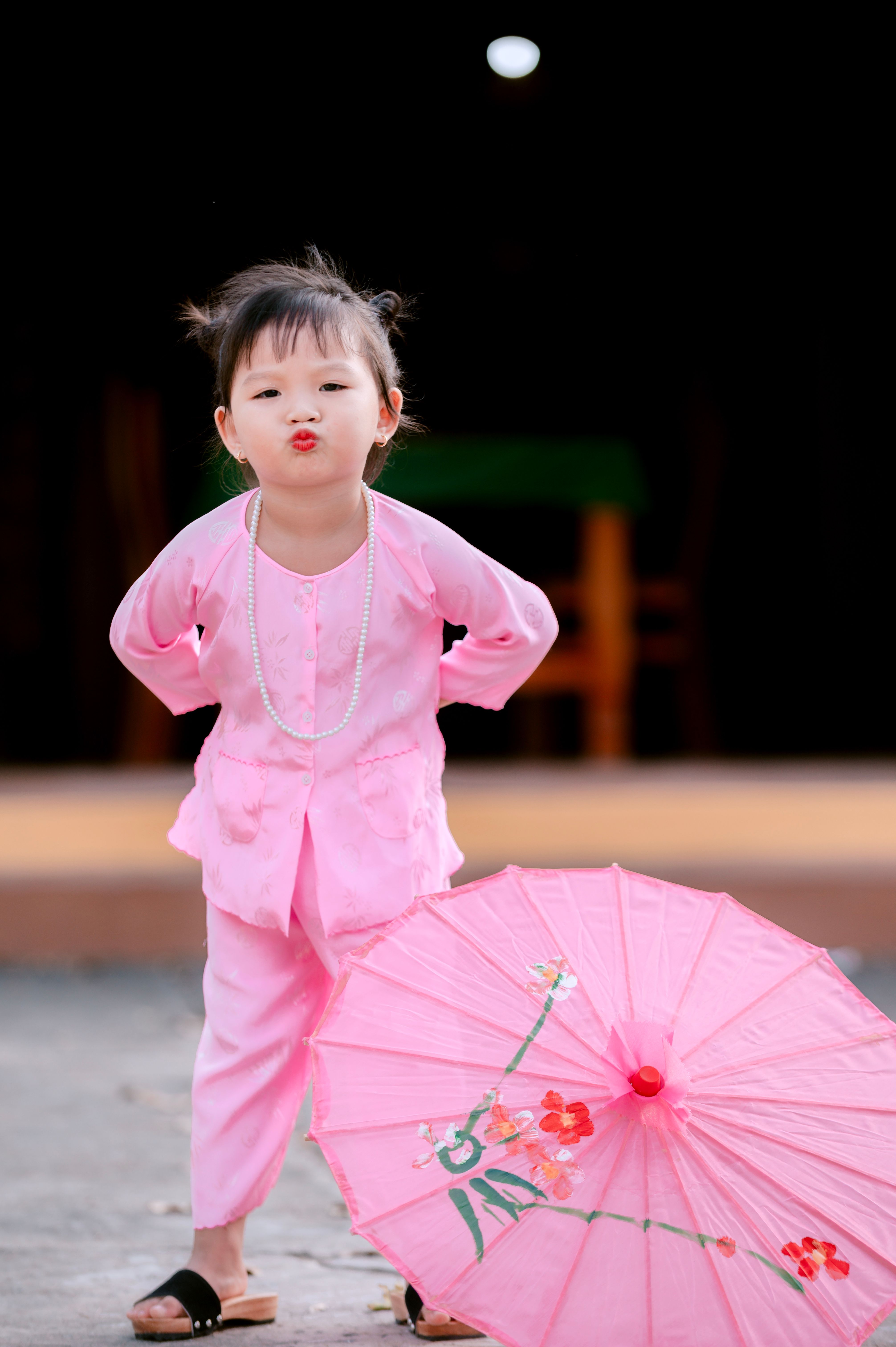 Cute Child in Pink Traditional Outfit with Umbrella · Free Stock Photo