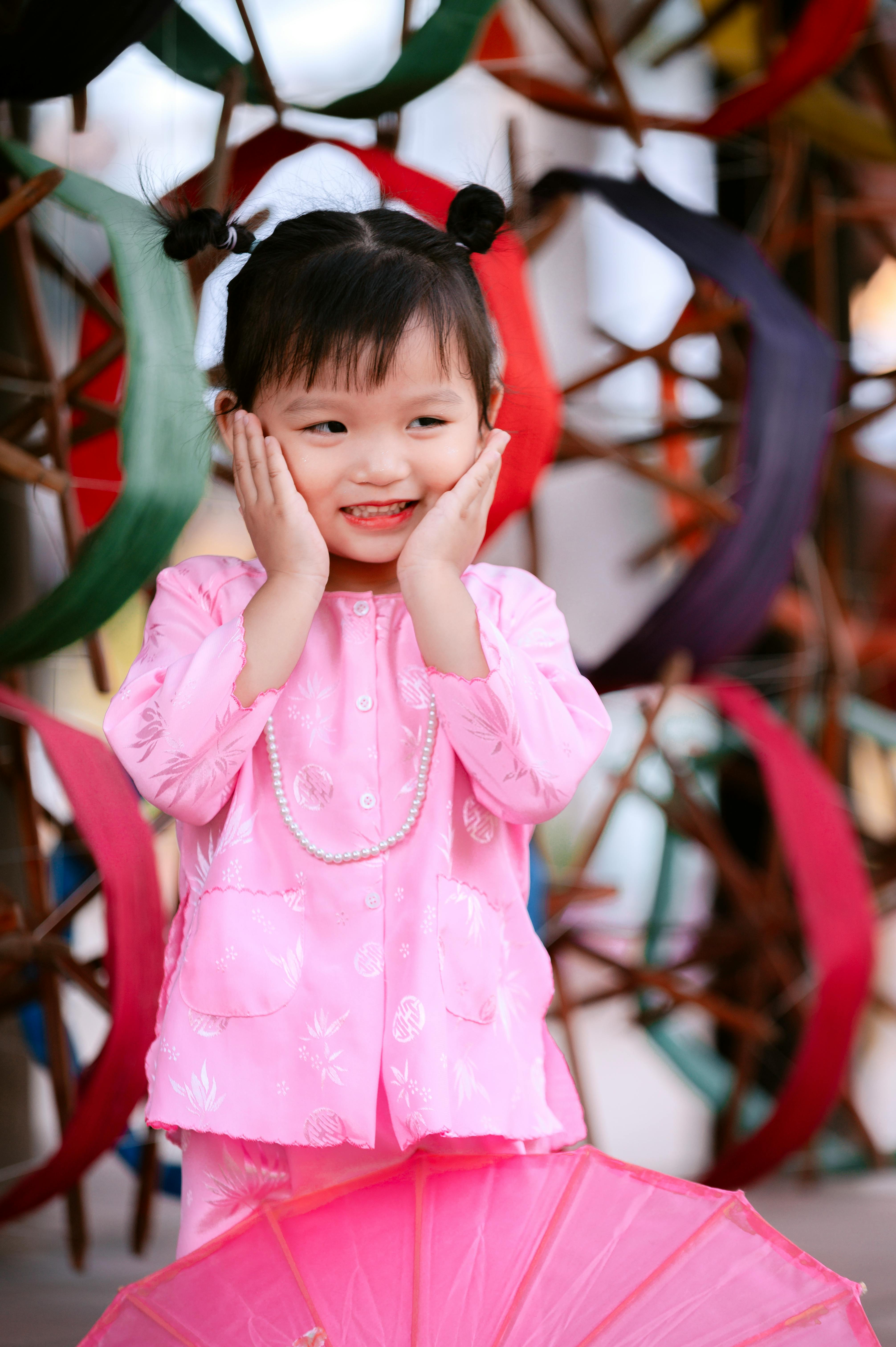 Joyful Child in Festive Pink Traditional Attire · Free Stock Photo