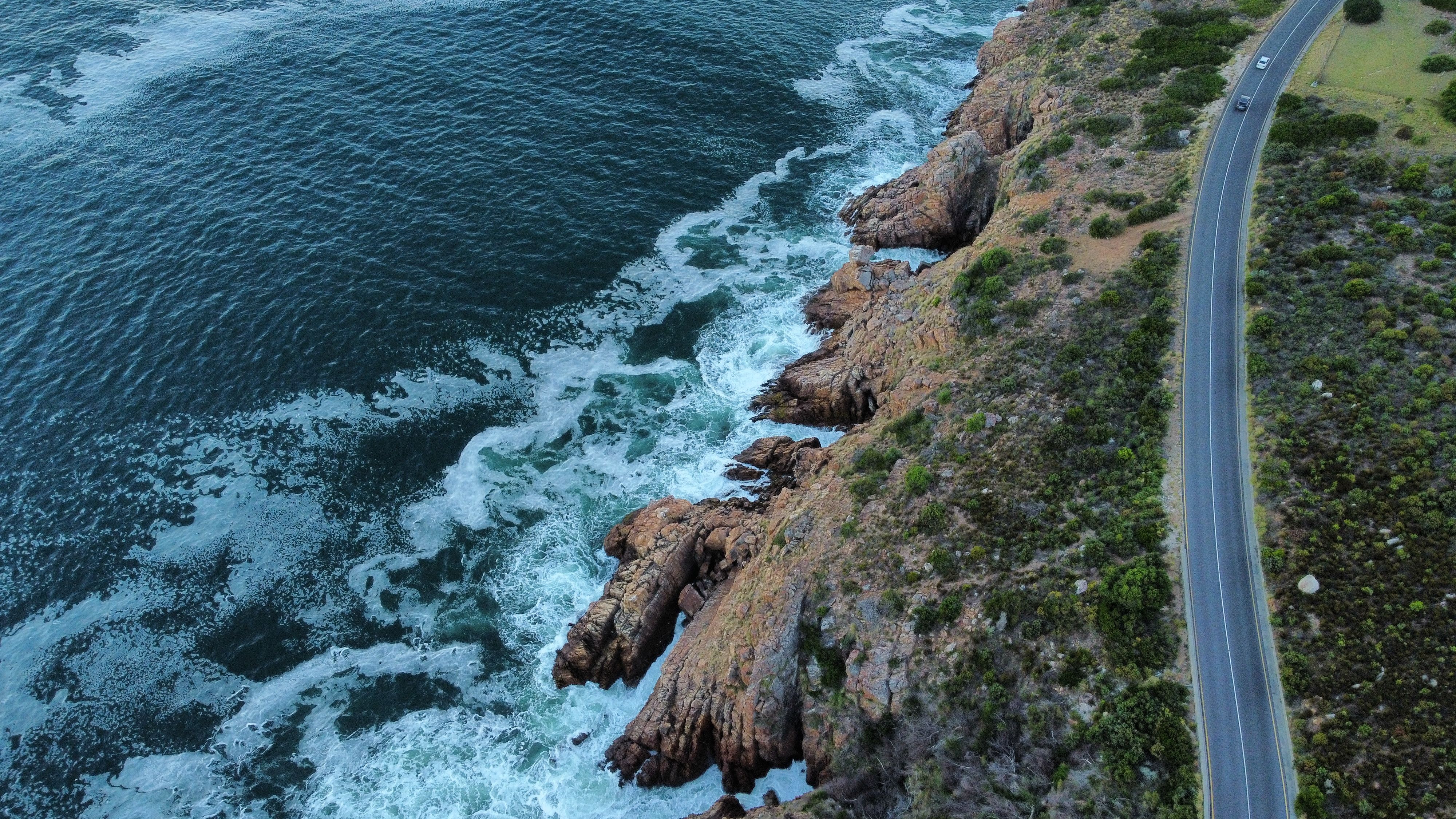 Aerial View of Coastal Road and Rocky Shoreline · Free Stock Photo