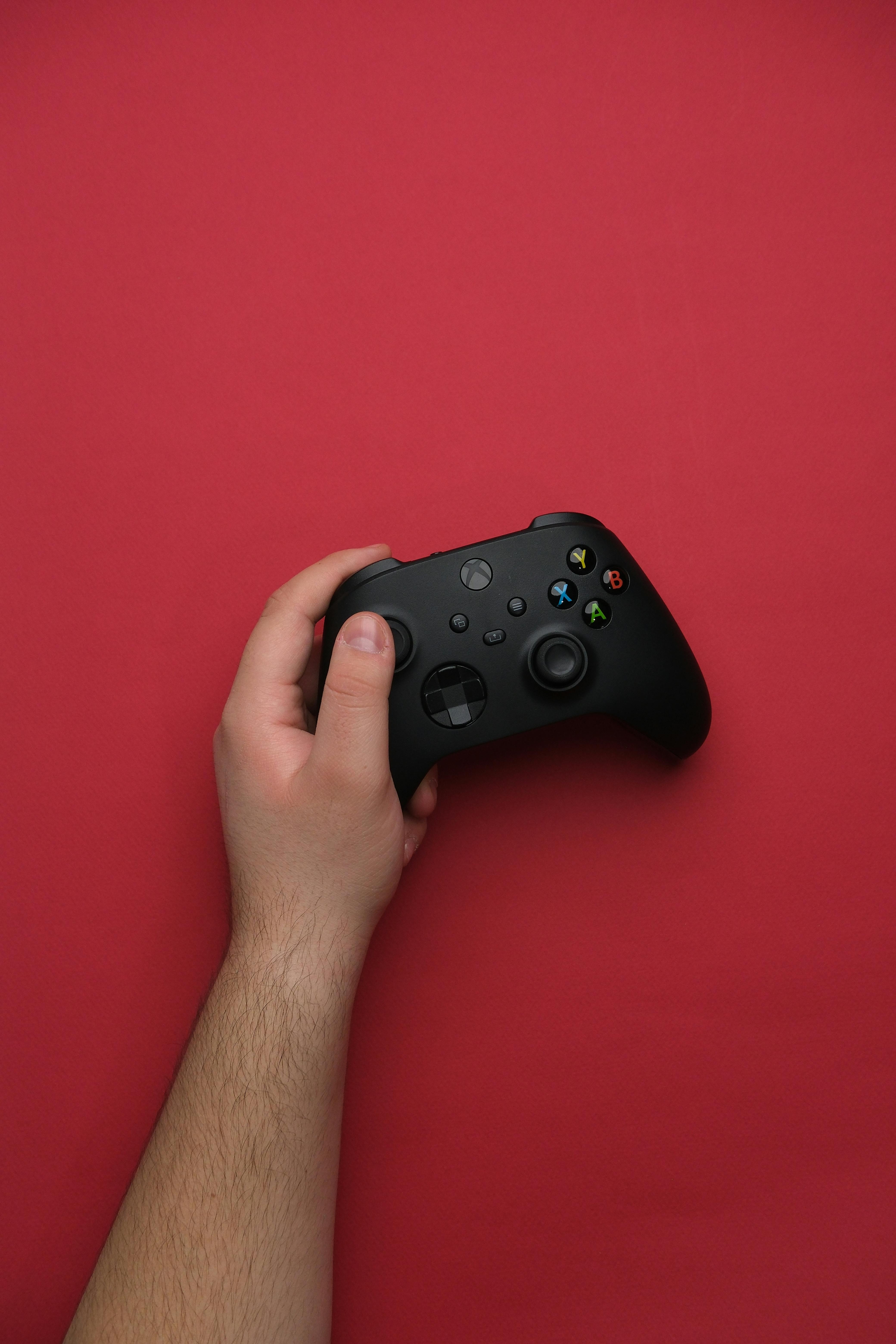 Close-up of Hand Holding Xbox Controller on Red Background · Free Stock ...