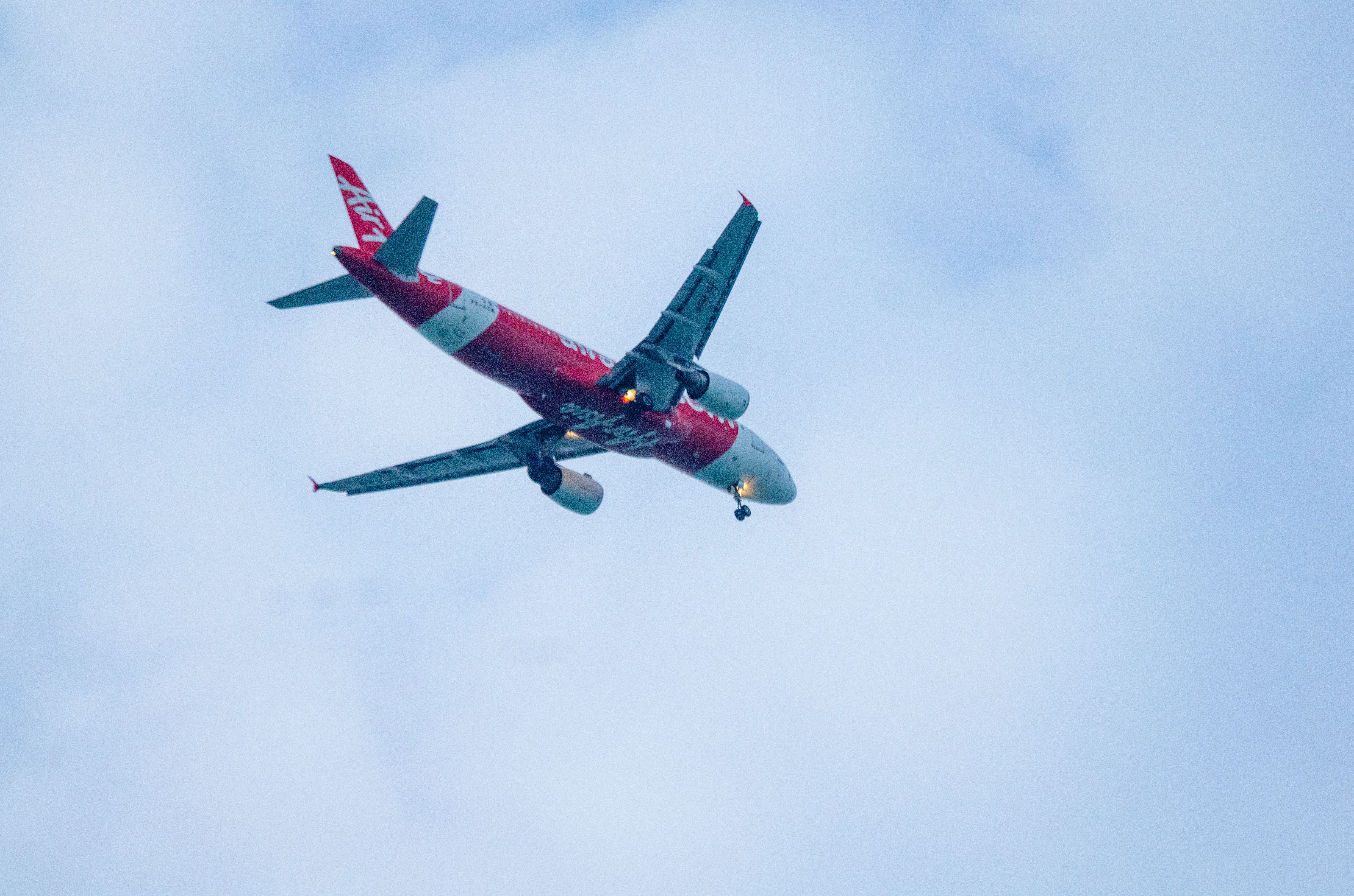 Avión Comercial Rojo Volando En Un Cielo Nublado · Foto de stock gratuita