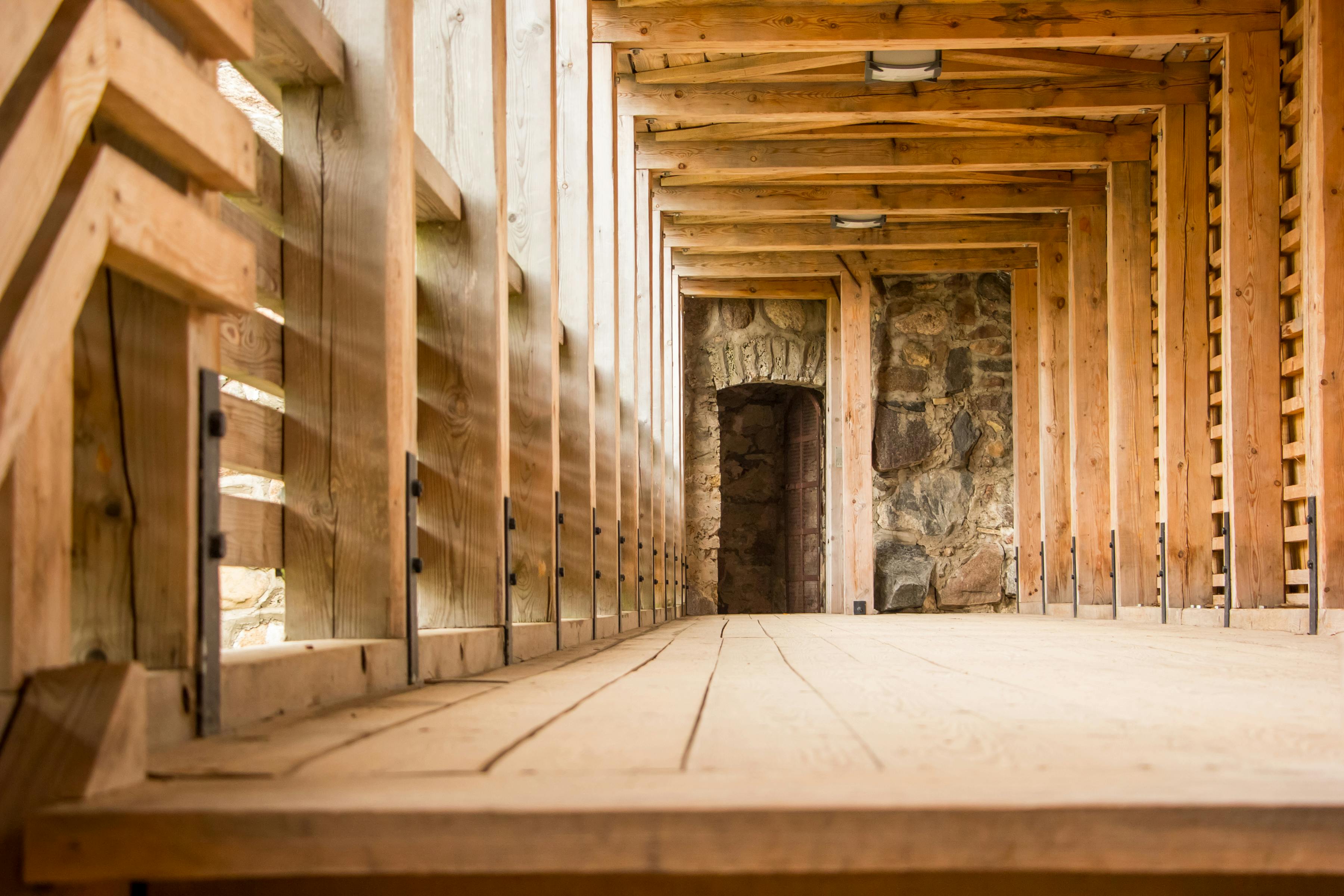 Rustic Wooden Corridor with Stone Wall · Free Stock Photo