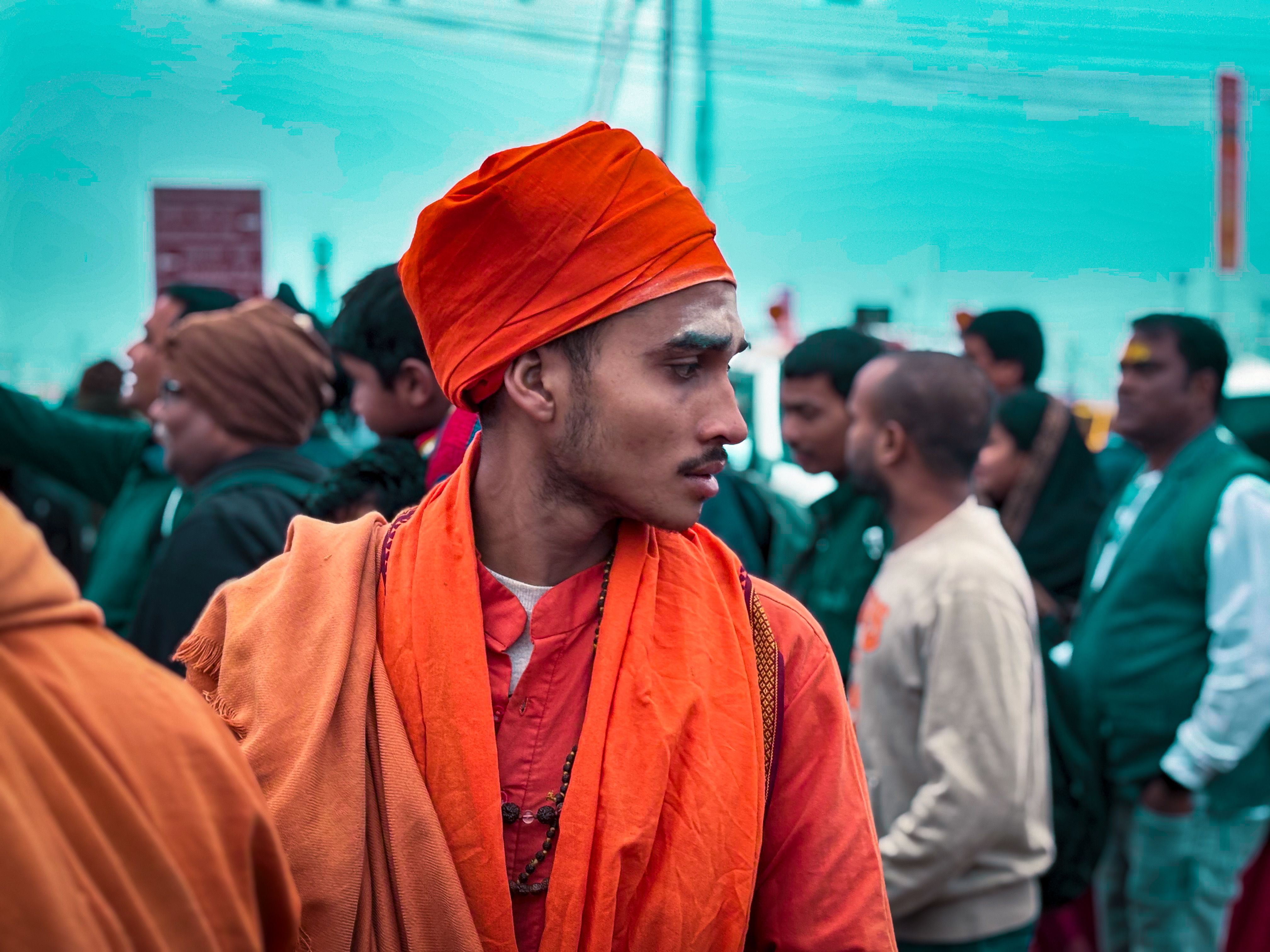 Young Man in Traditional Orange Garb at Gathering · Free Stock Photo