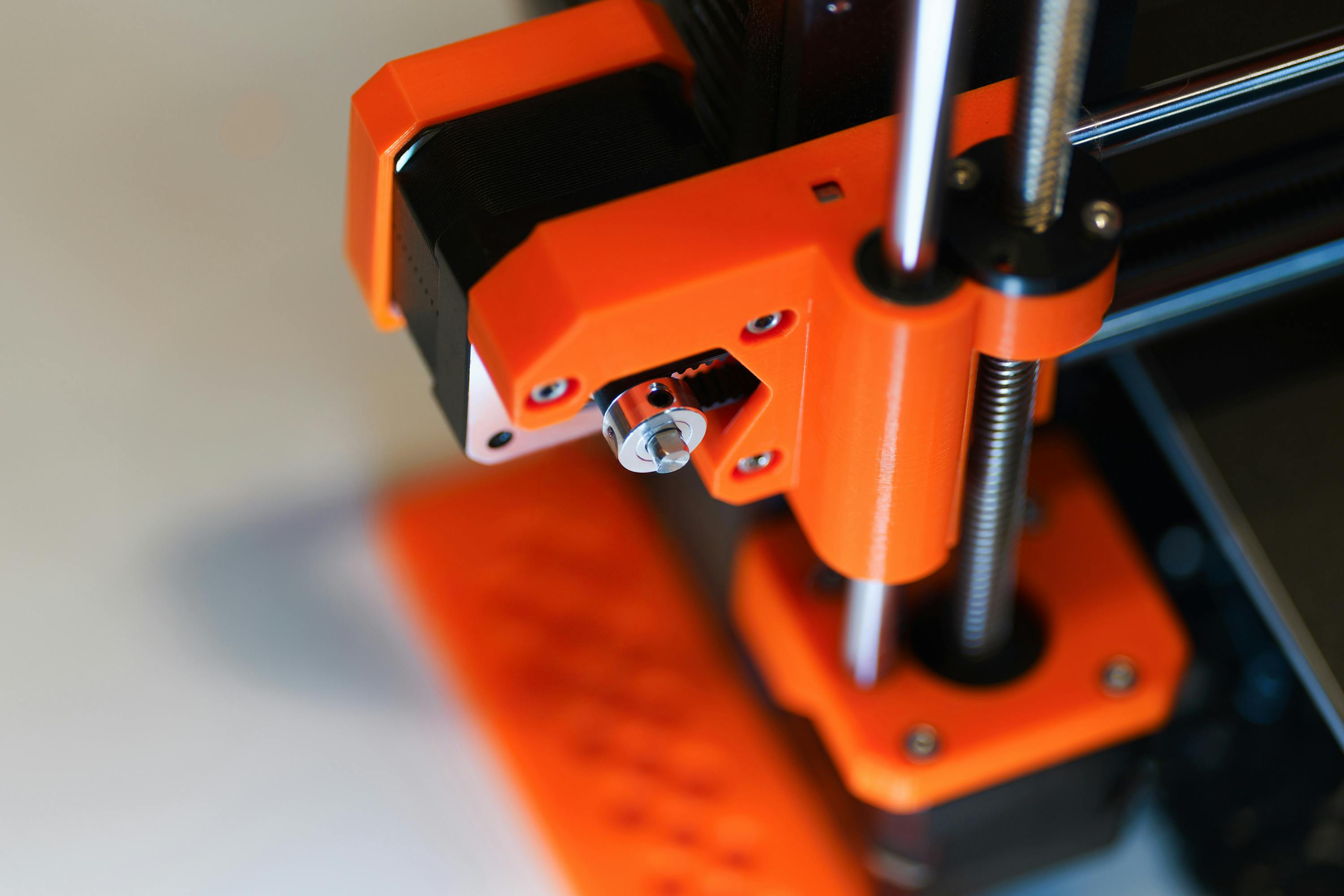 Close-up of an Orange 3D Printer Component · Free Stock Photo