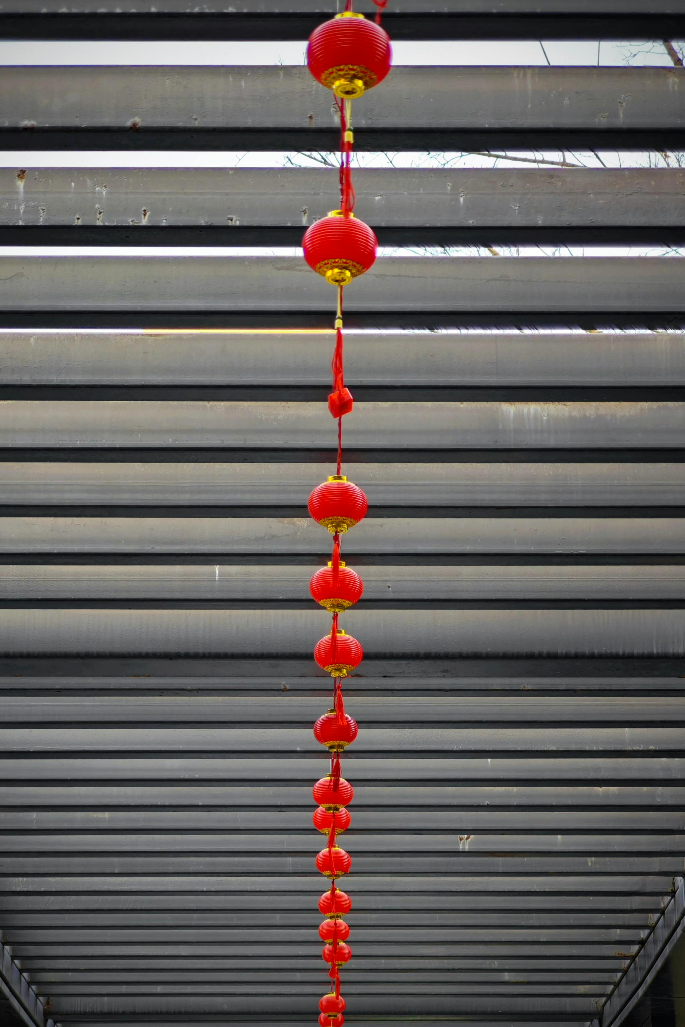 Vertical Red Lanterns Hanging in Architectural Structure · Free Stock Photo