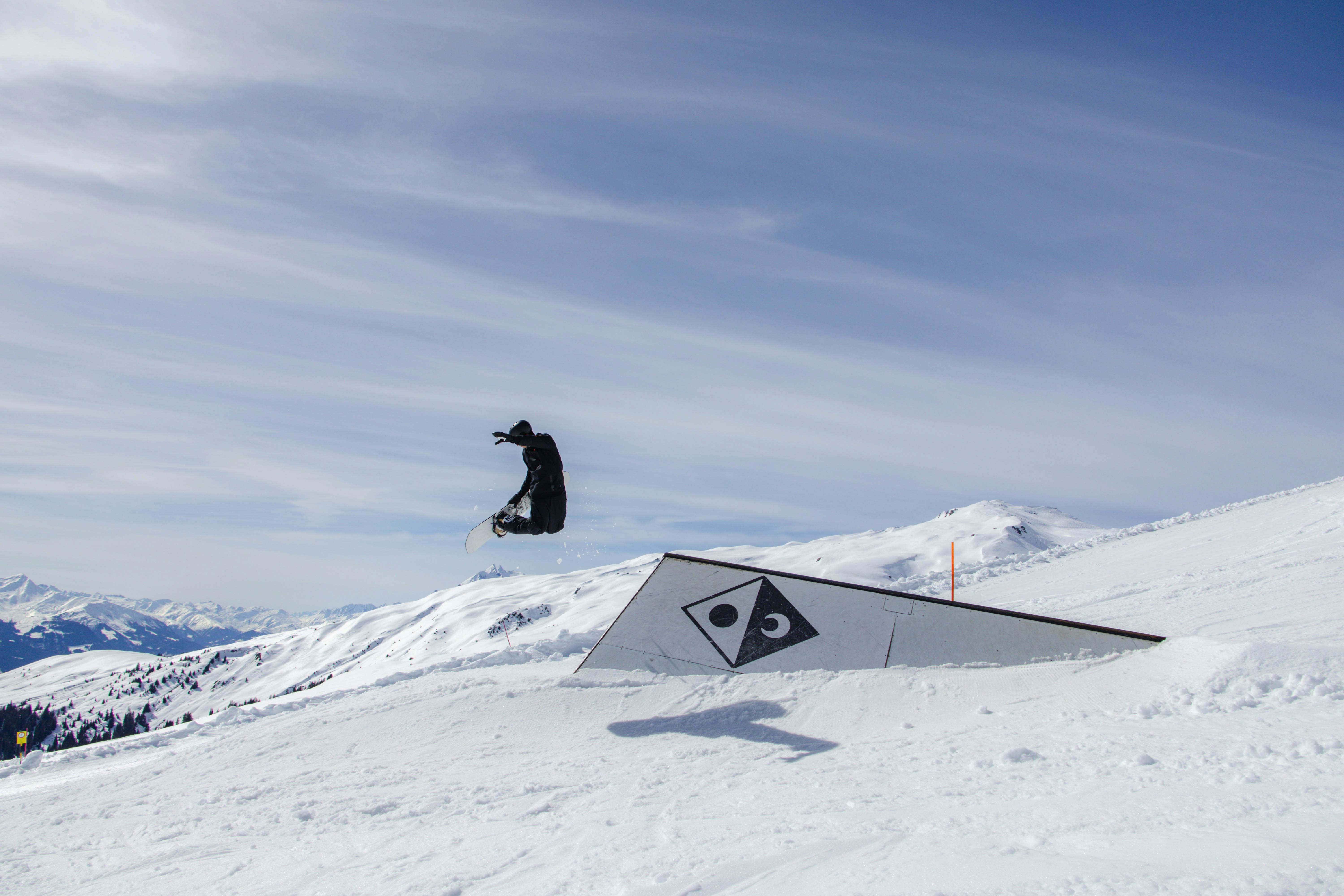 Man in Black Snowboard With Binding Performs a Jump · Free Stock Photo