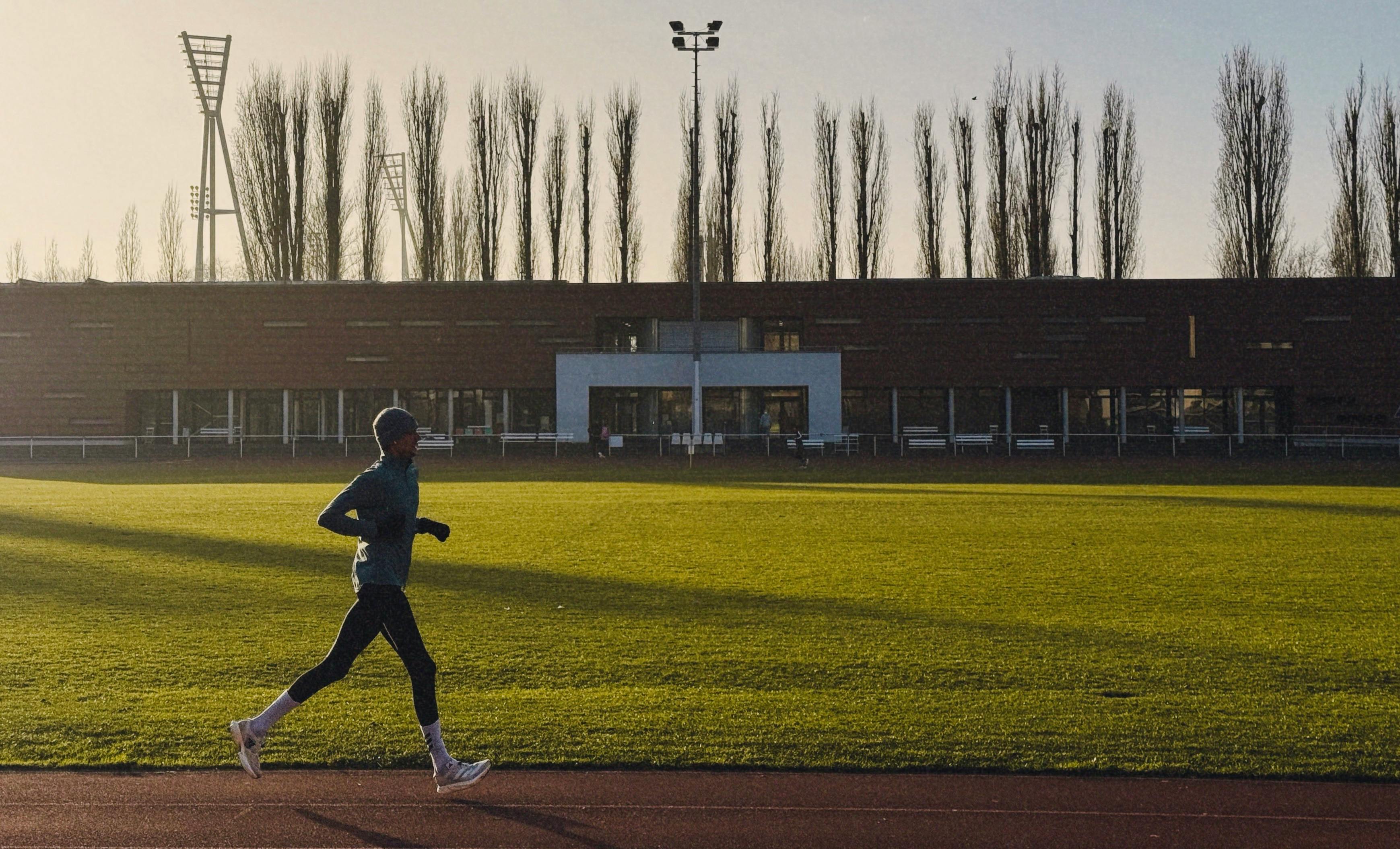 Man Jogging on Track in Berlin at Sunrise · Free Stock Photo