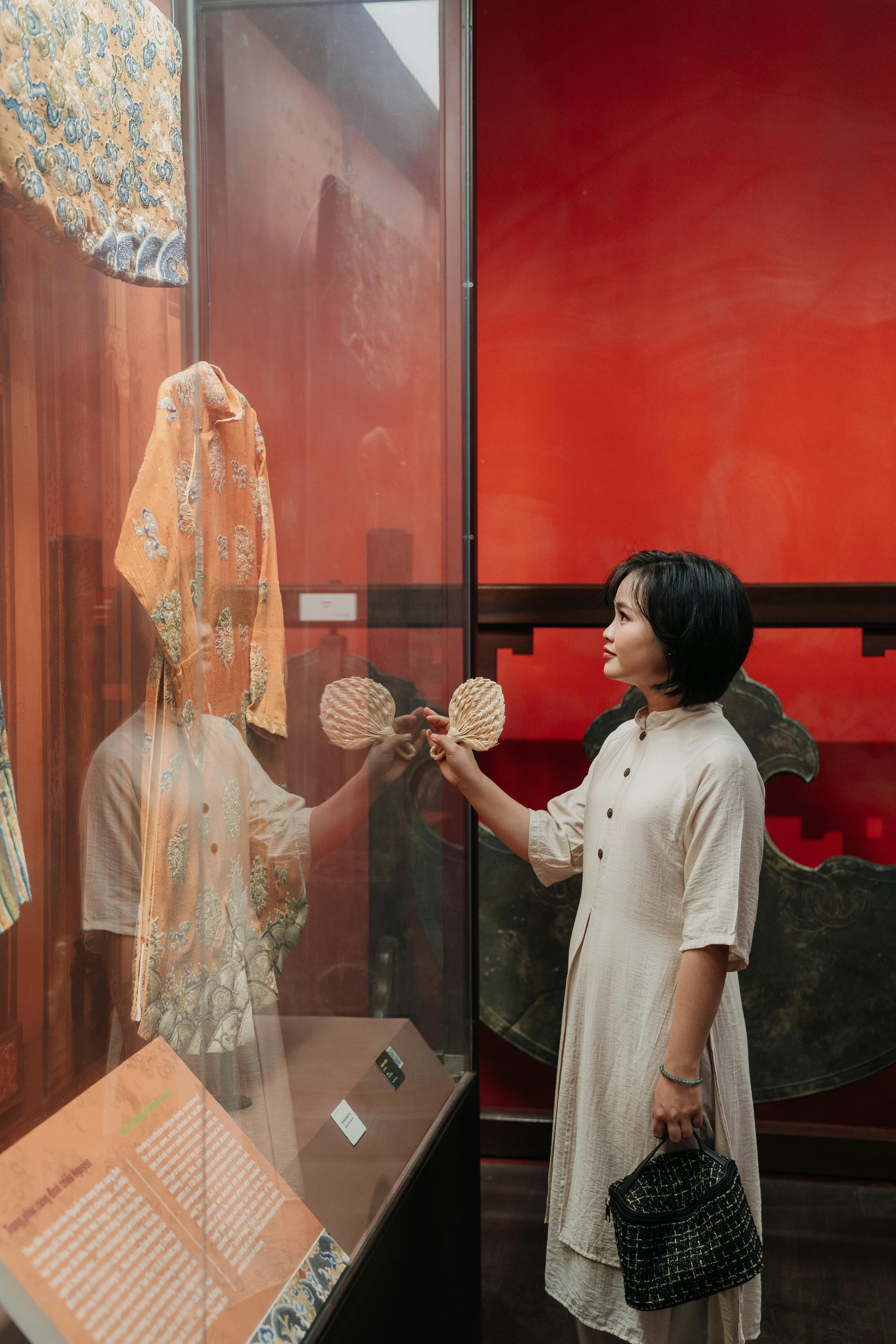 Woman Observes Traditional Asian Textile in Museum · Free Stock Photo