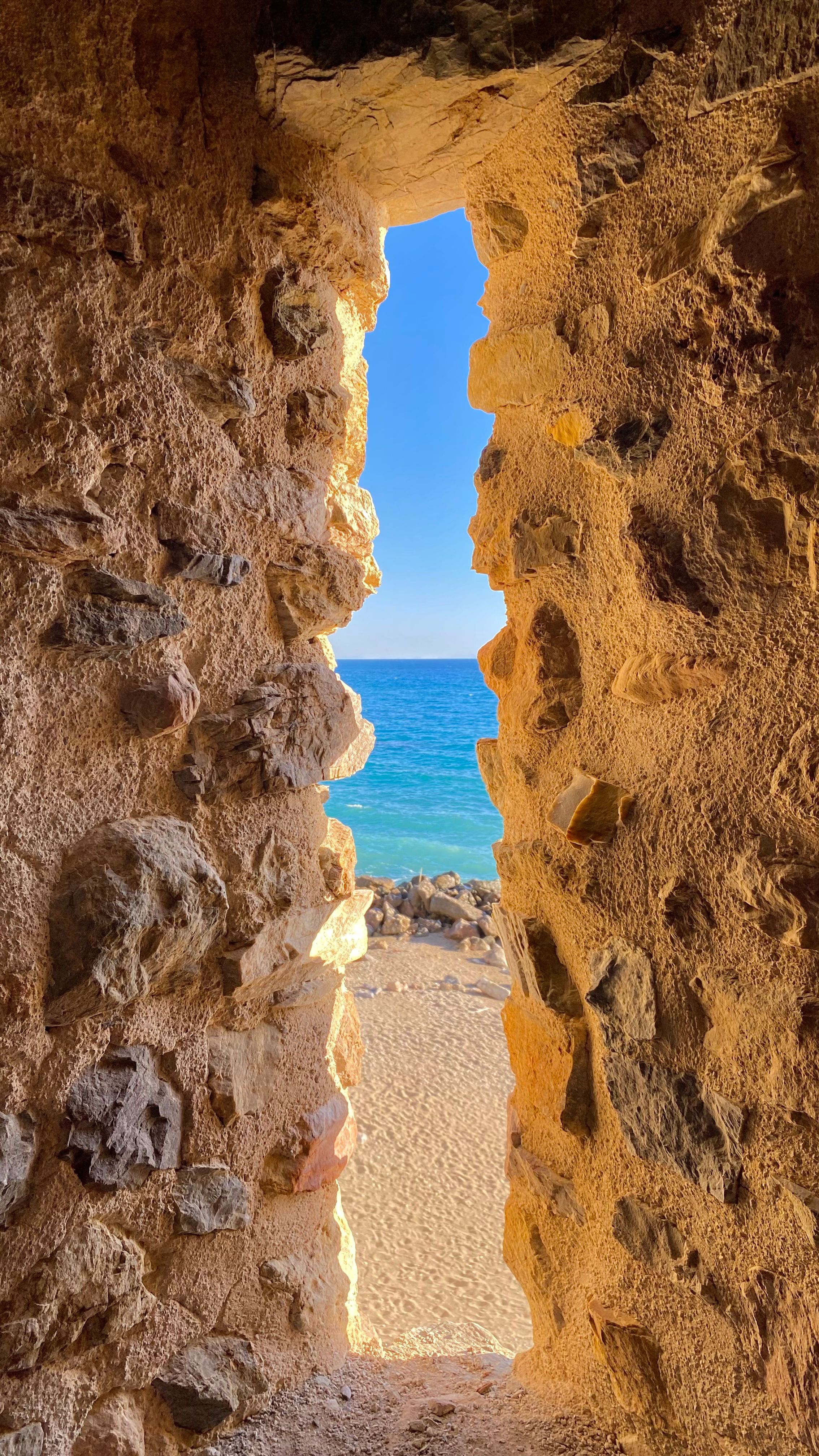 Scenic Ocean View Through Ancient Stone Wall · Free Stock Photo