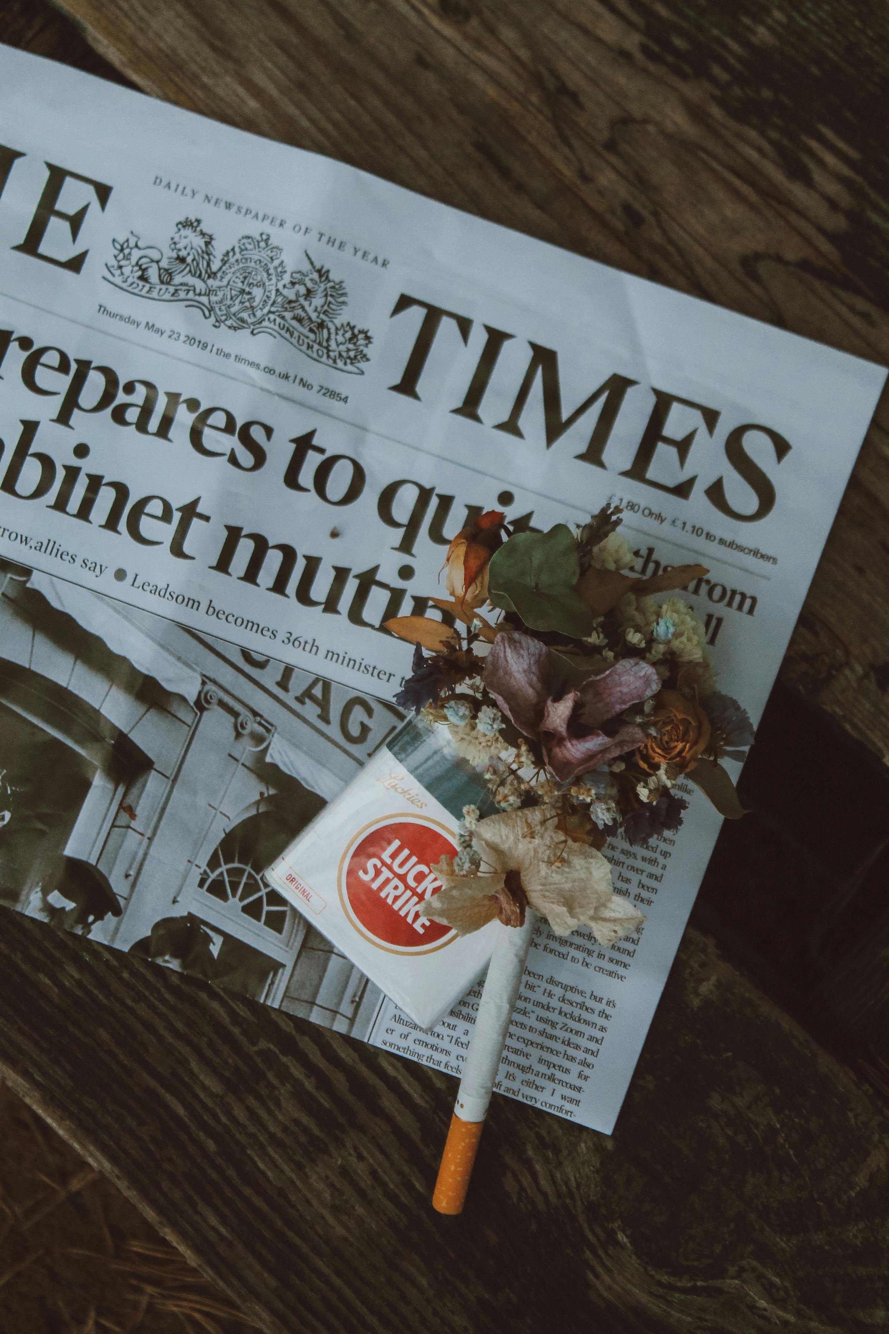 Vintage Newspaper with Cigarette and Flowers · Free Stock Photo