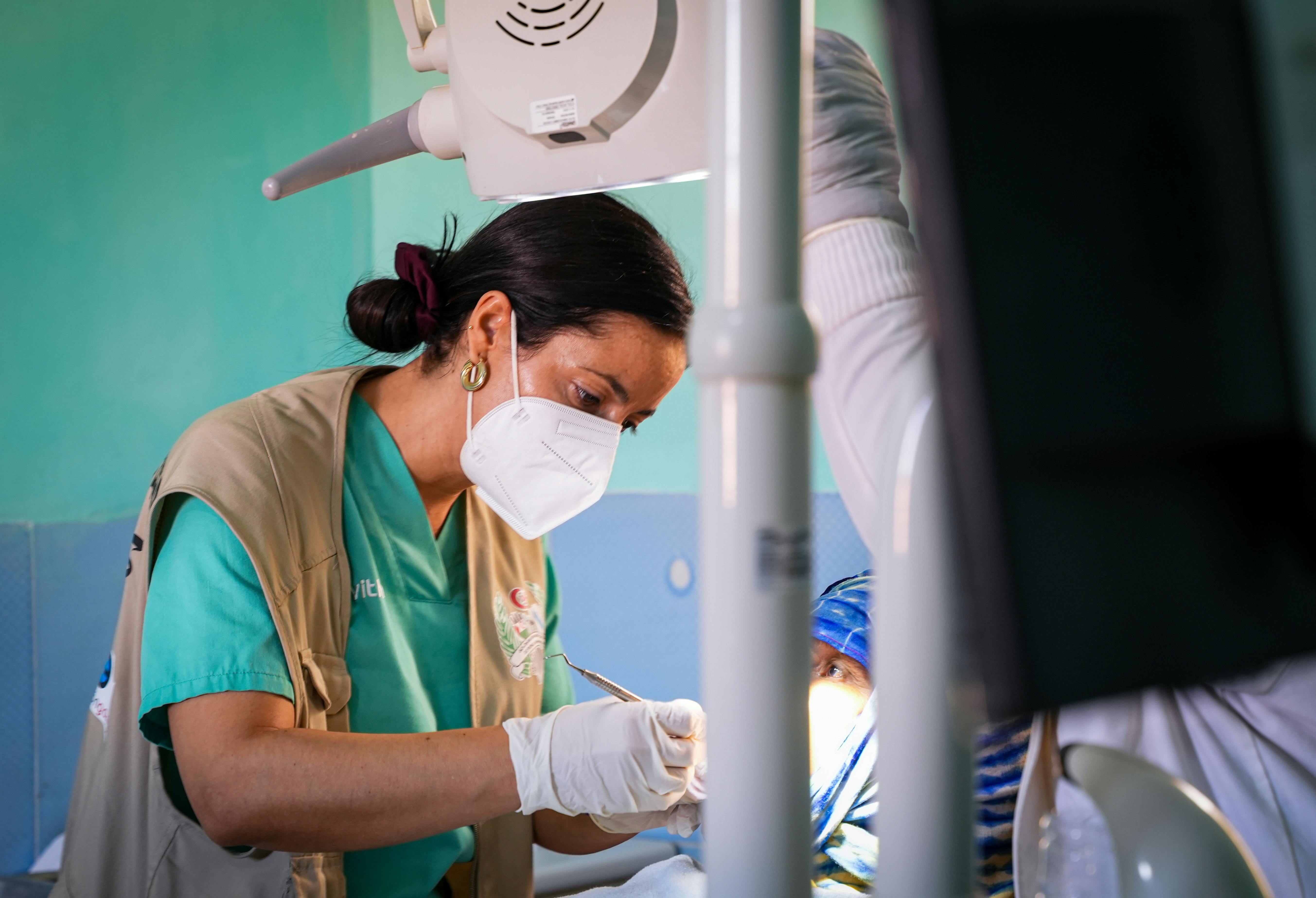 Female Doctor Performing Medical Procedure Indoors · Free Stock Photo