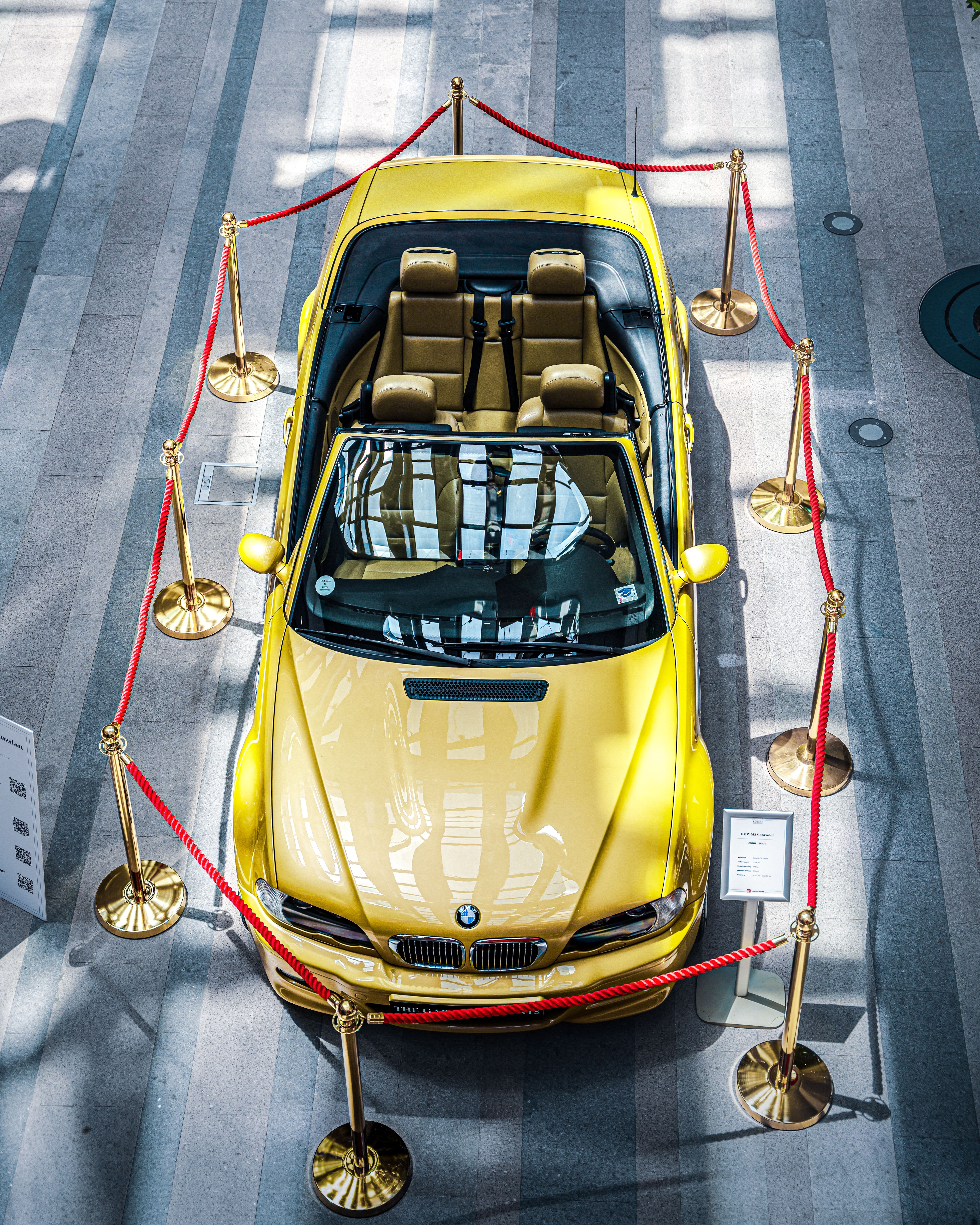 Sleek Yellow BMW Convertible Displayed Indoors · Free Stock Photo